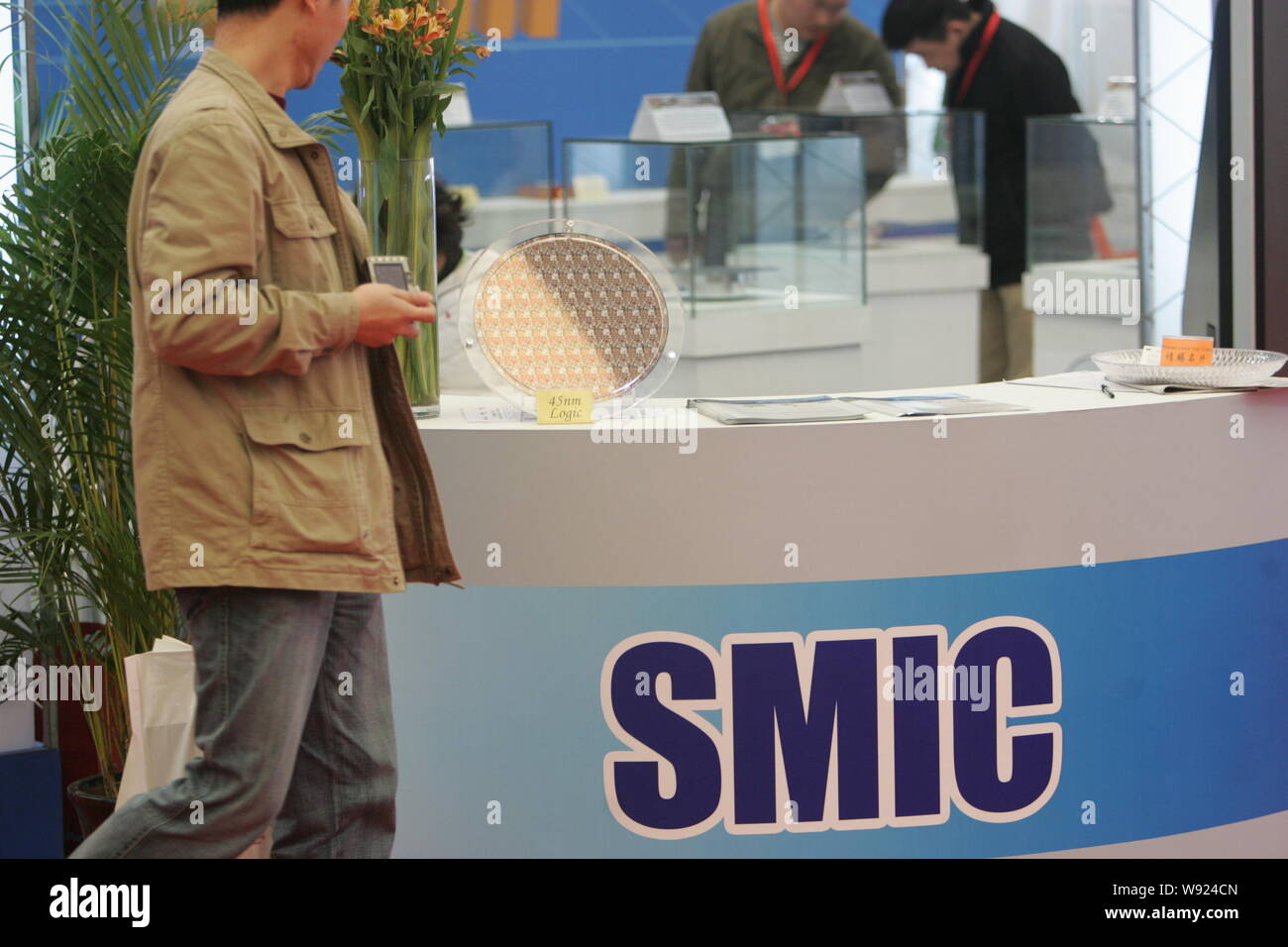 --FILE--Chinese visitors look at wafers at the booth of SMIC ...