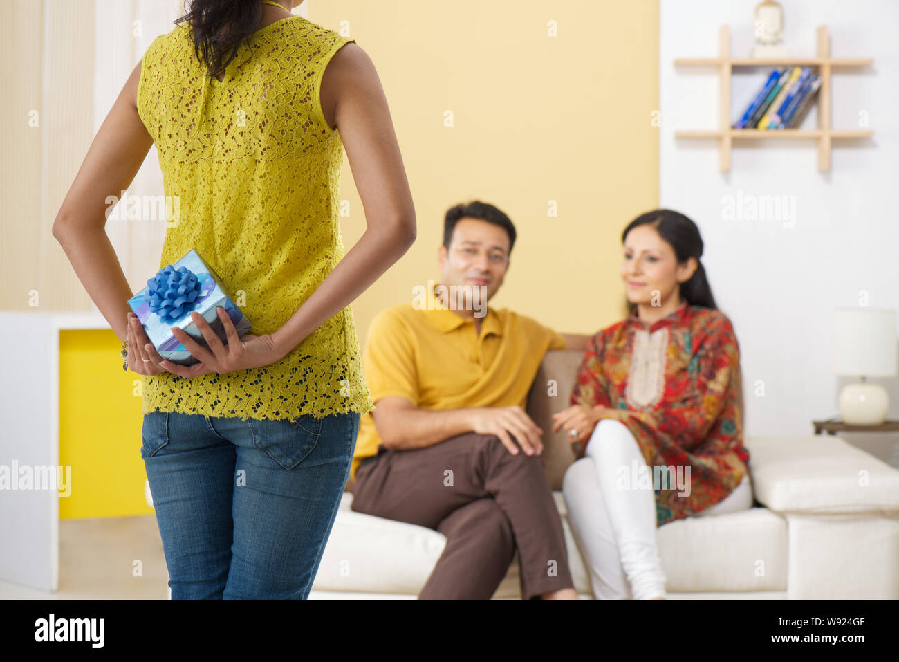 Girl hiding a present from her parents Stock Photo - Alamy