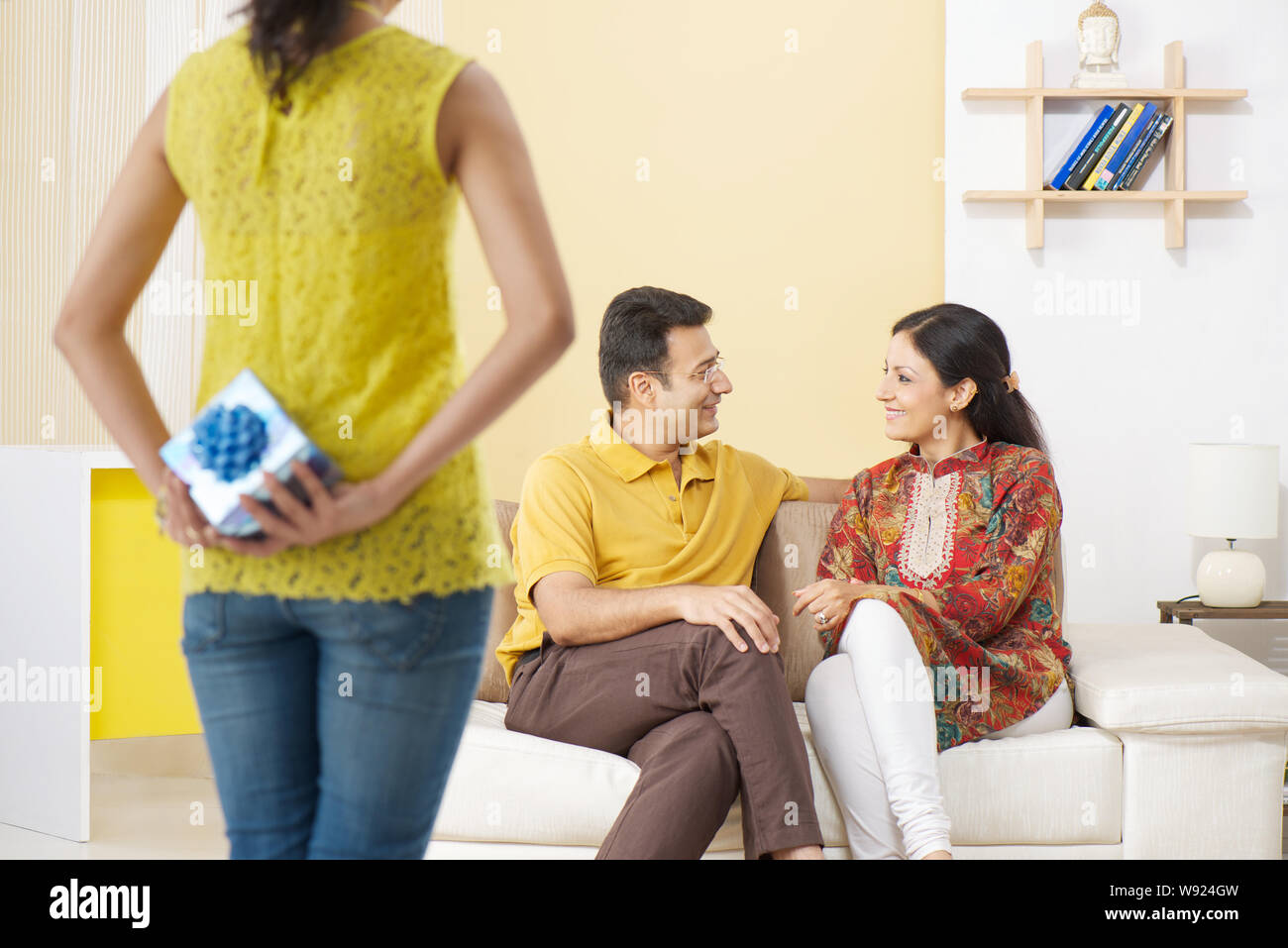 Girl hiding a present from her parents Stock Photo - Alamy