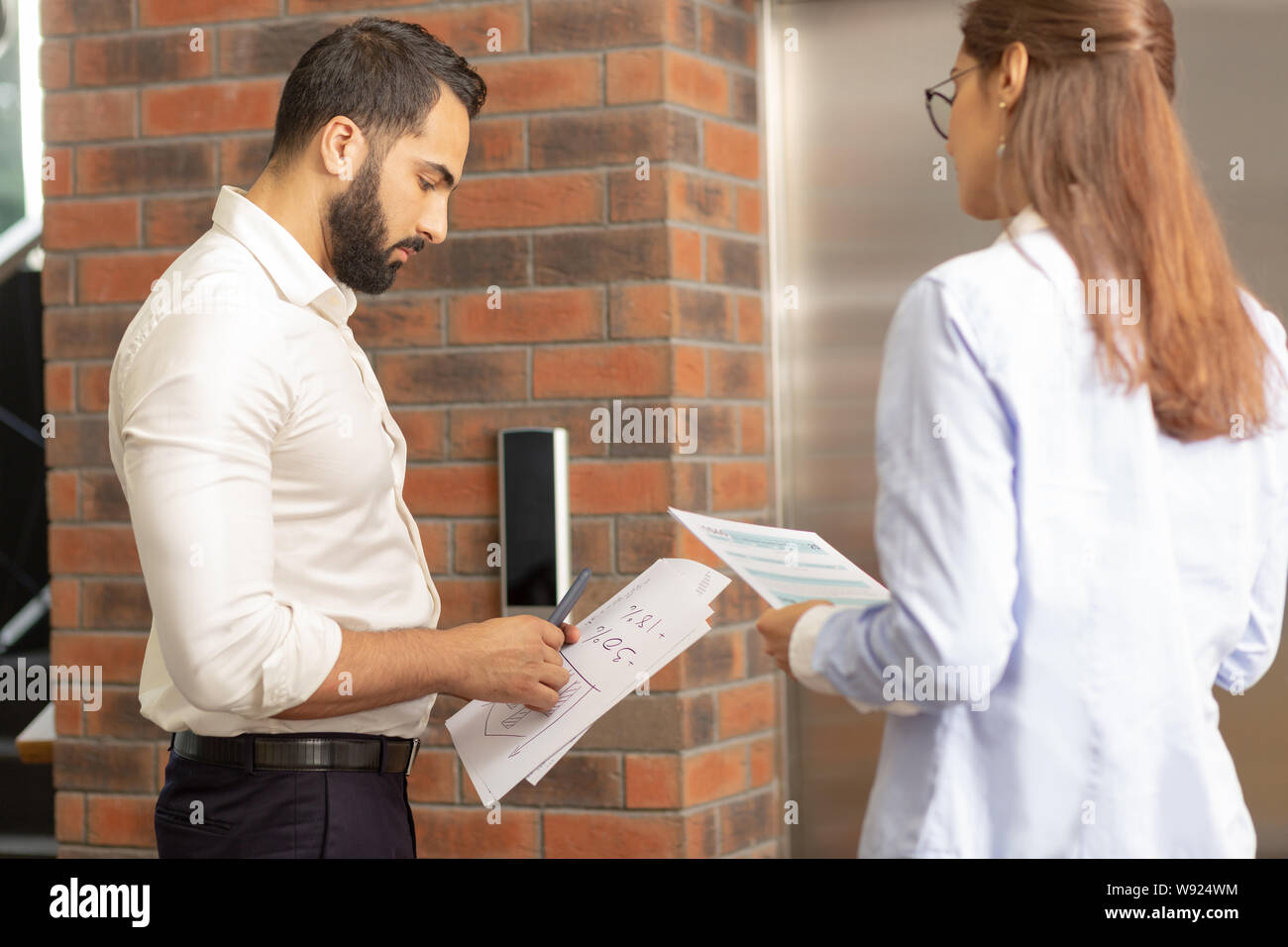 Young office workers waiting for elevator together Stock Photo - Alamy