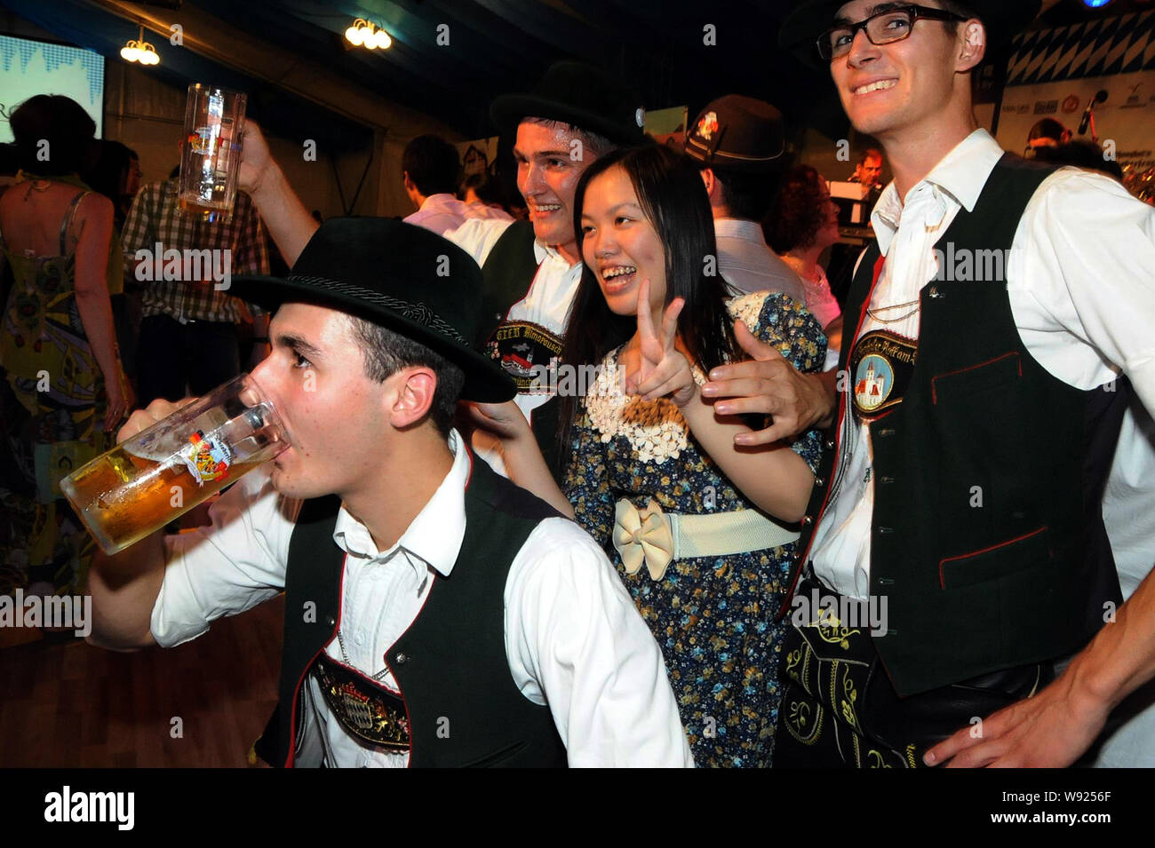 Waiters pose with a guest during the 16th Shanghai Germany Beer ...