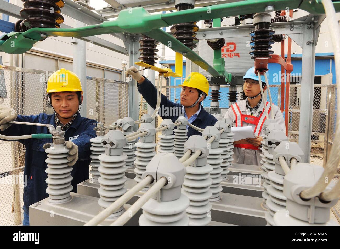 Chinese workers maintain the power lines at the 110KV Dongyang ...