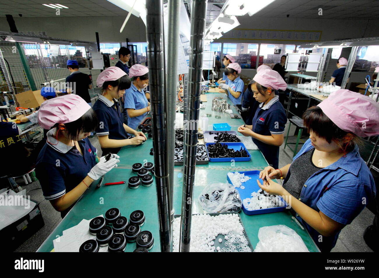 Female Chinese workers assemble caps of vacuum bottles at the plant of ...