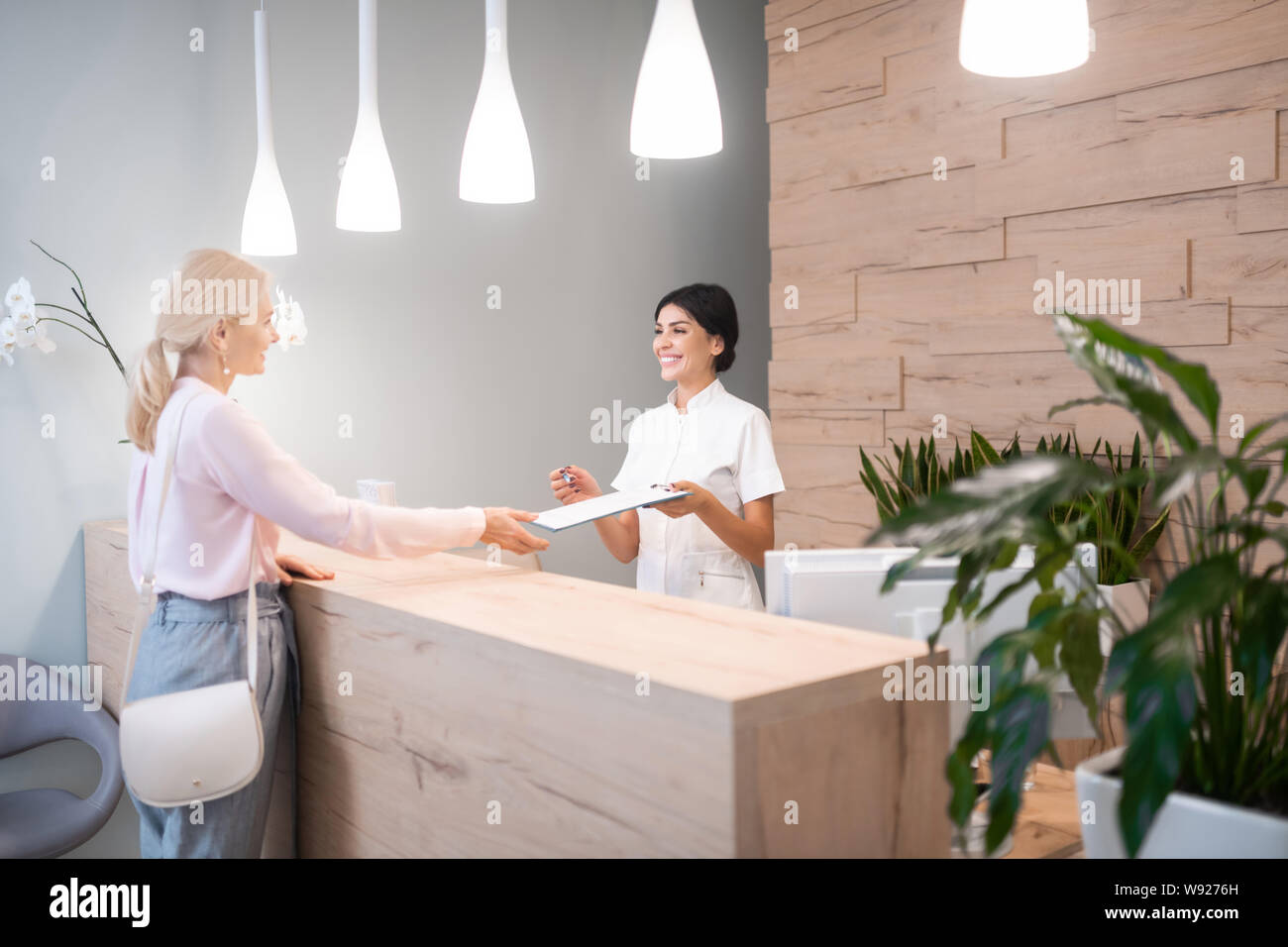 Woman standing at reception of dental clinic Stock Photo - Alamy