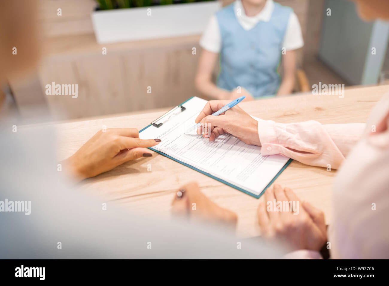 Doctor pointing her patient where to sign the form Stock Photo - Alamy