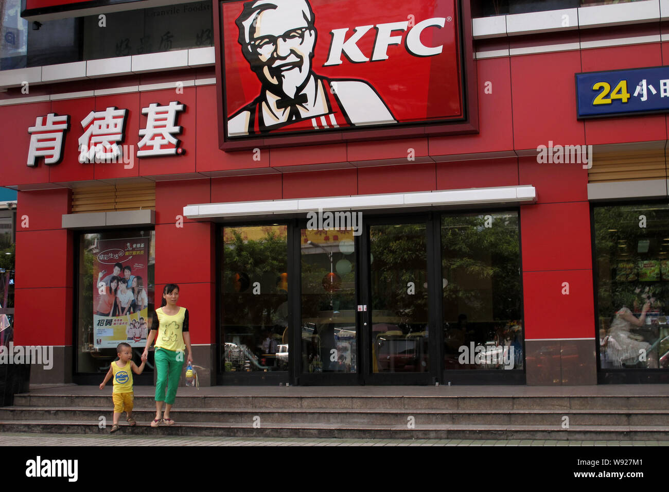 Pedestrians walk past a KFC fastfood restaurant in Haikou city, south ...