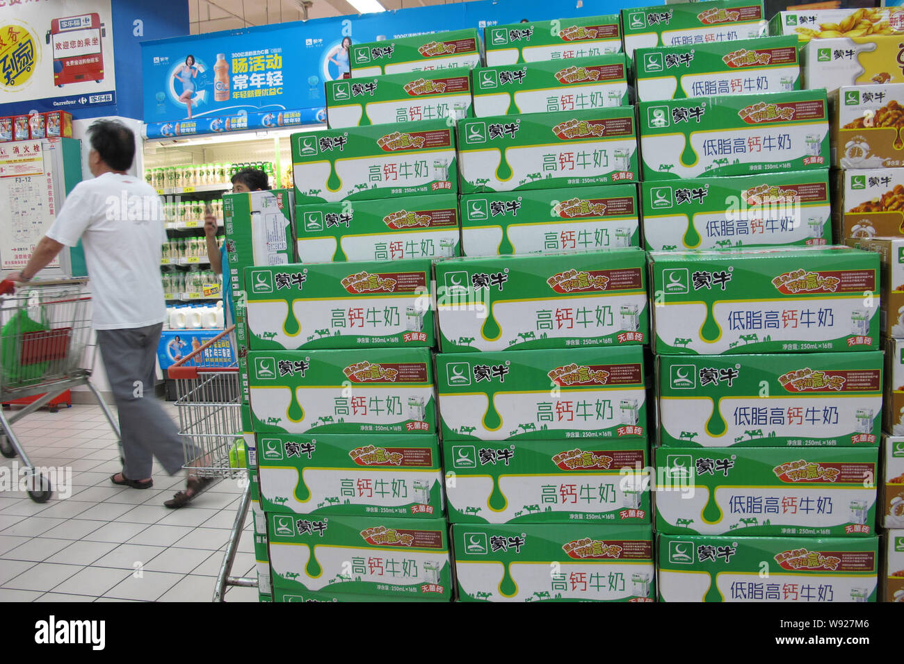 --FILE--A customer walks past cartons of Mengniu milk at a supermarket ...