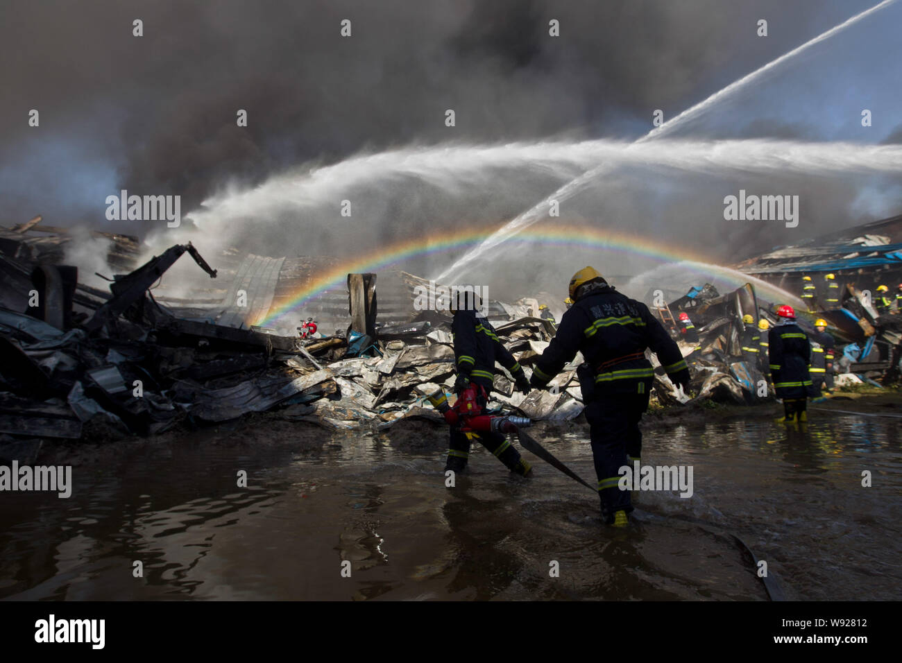 Chinese firefighters hose water to extinguish the fire at a factory of ...