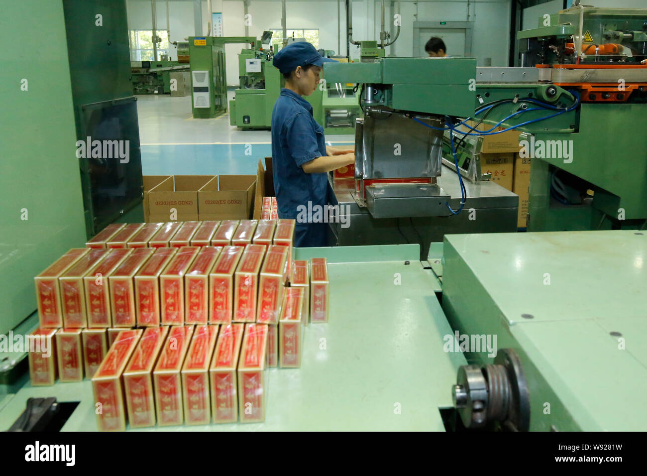 --FILE--A worker produces carton of cigarettes at an assembly line at a ...