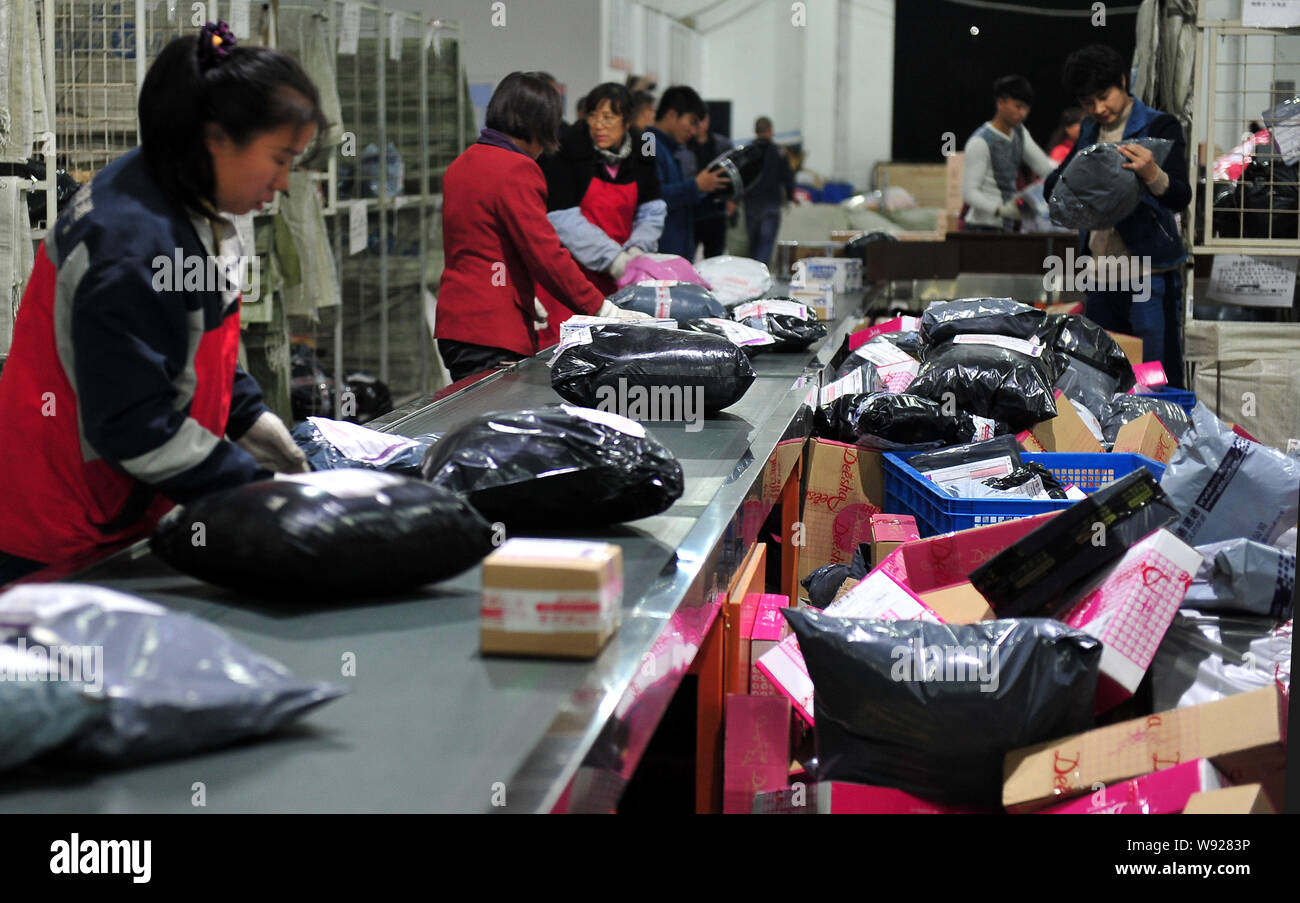 Chinese workers sort parcels, most of which come from online shopping, at a dispatch center of ...
