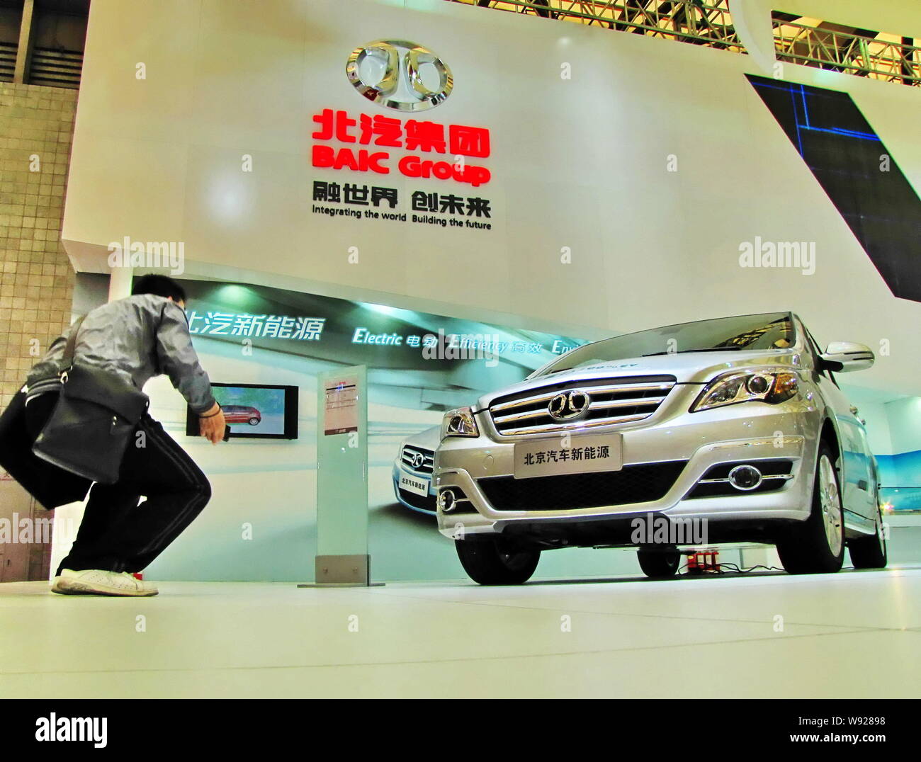 --FILE--A visitor looks at a car at the stand of BAIC Group, also known ...