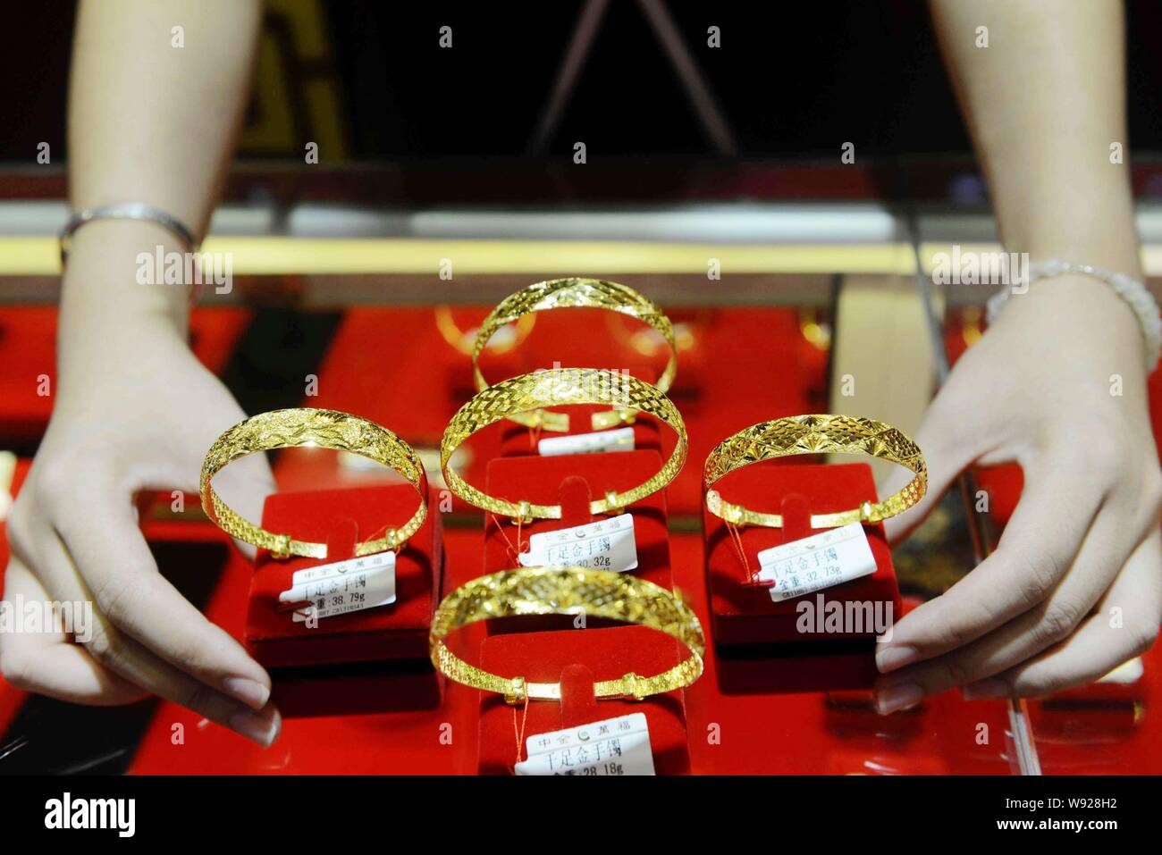 --FILE--A Chinese clerk puts gold bracelets into a counter at a gold ...