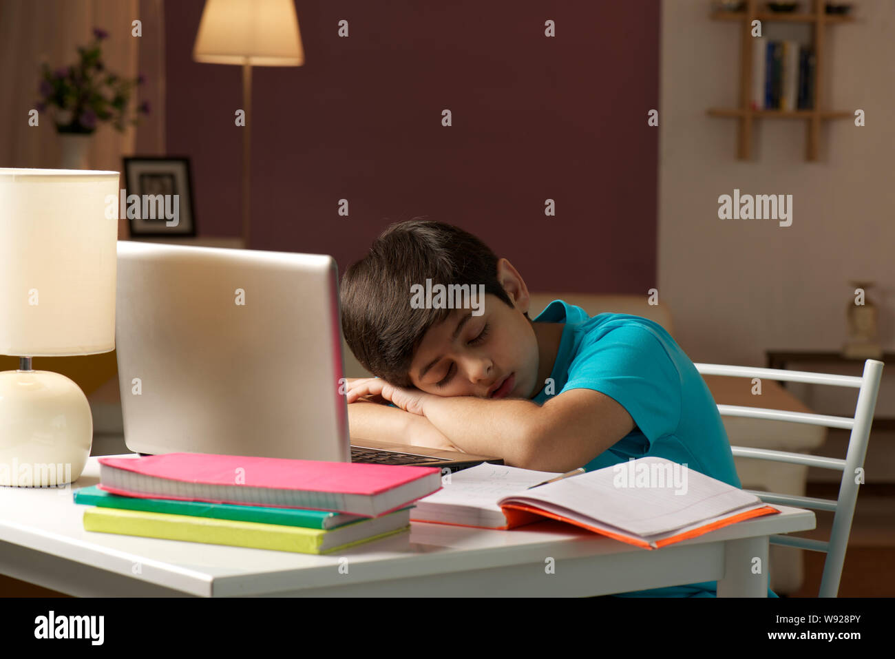 Boy napping on a desk in a study room Stock Photo - Alamy