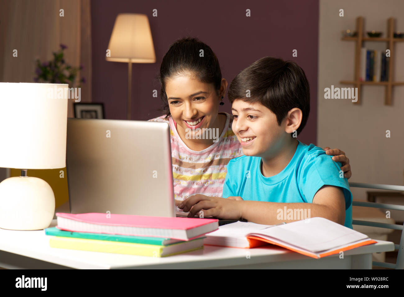 Boy using laptop with his sister Stock Photo - Alamy