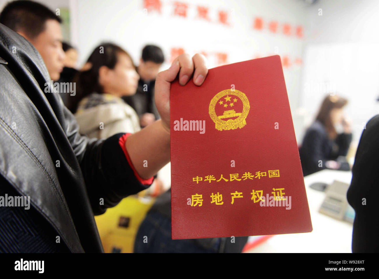 A Chinese person shows a property right certificate at a real estate ...