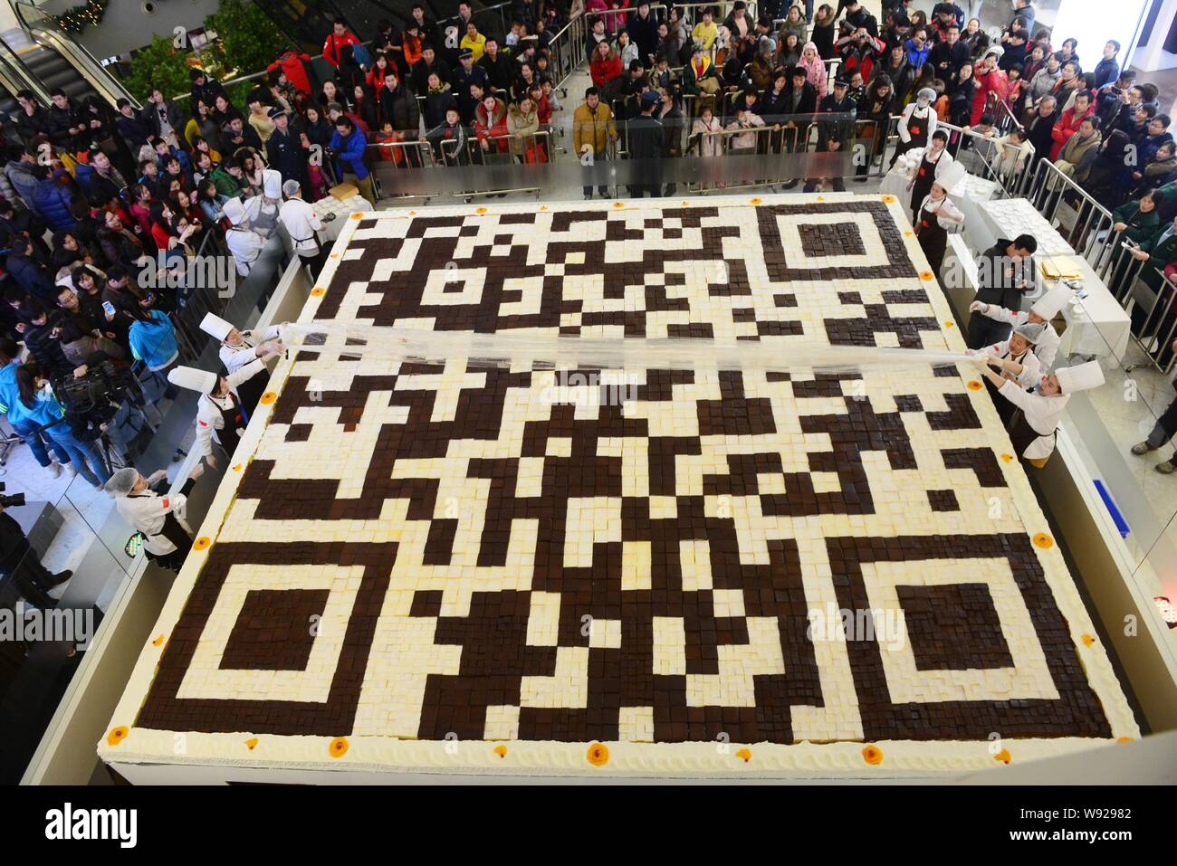 Shoppers look at a giant QR code cake displayed at Raffles City ...