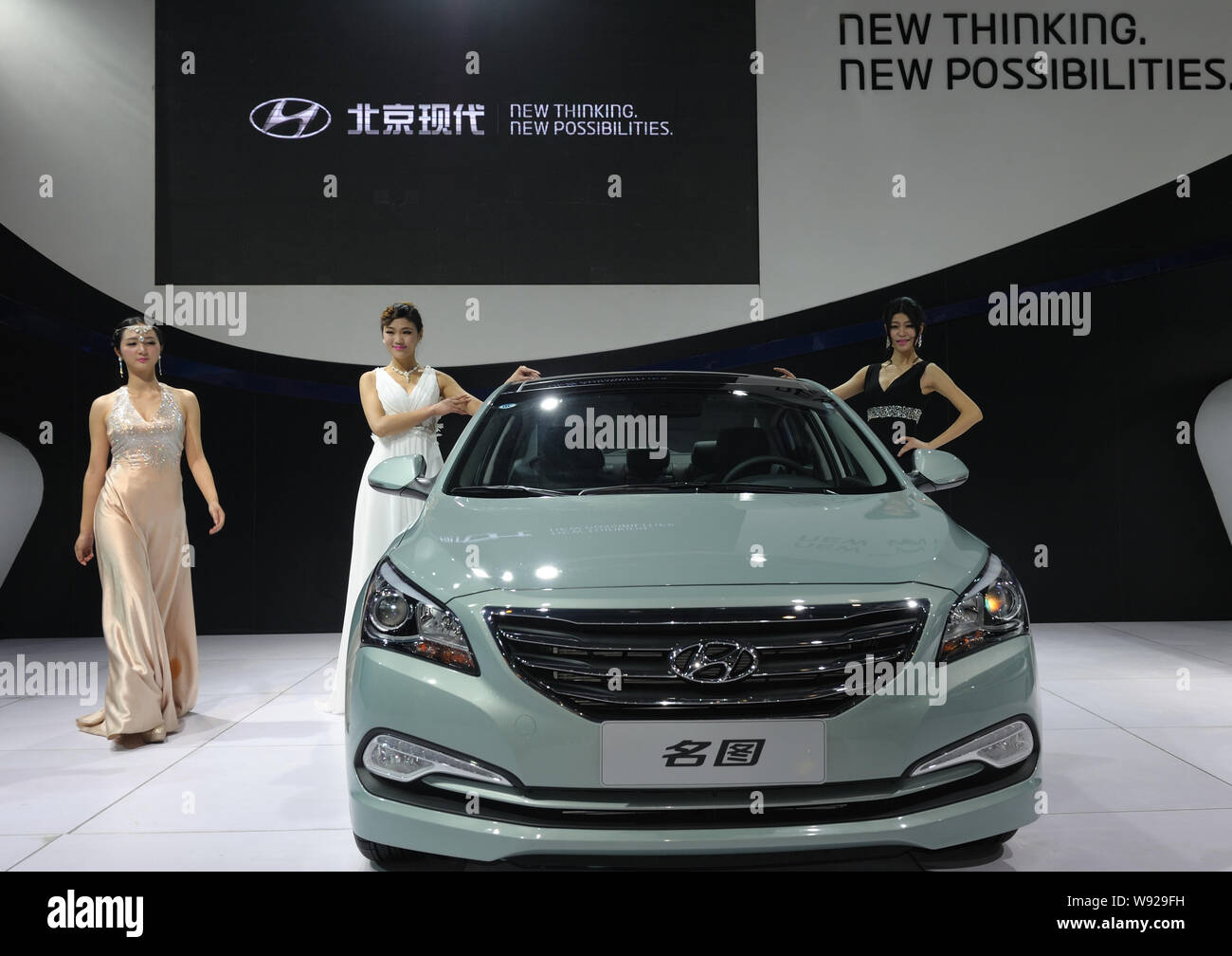 --FILE--Models pose with a Hyundai Mistra at the stand of Beijing ...