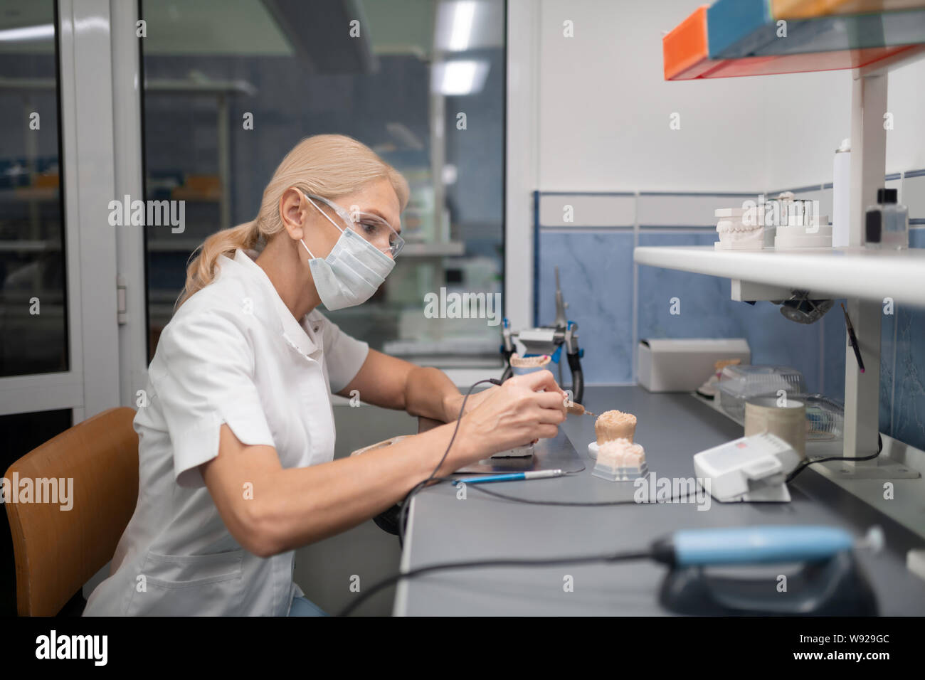 Dental technician making porcelain veneers for the patient Stock Photo ...