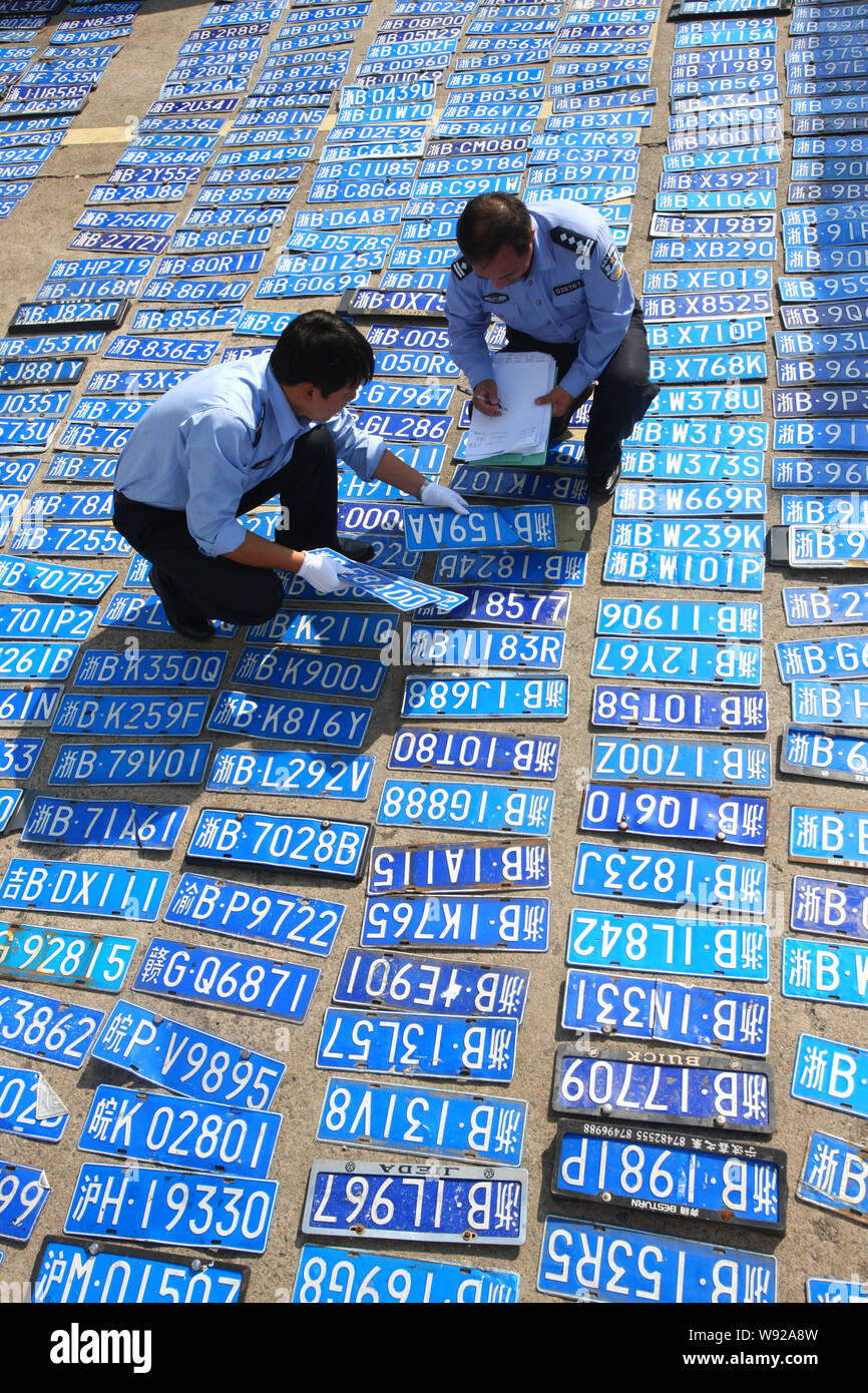 Chinese police officers check and register unclaimed car plates which ...