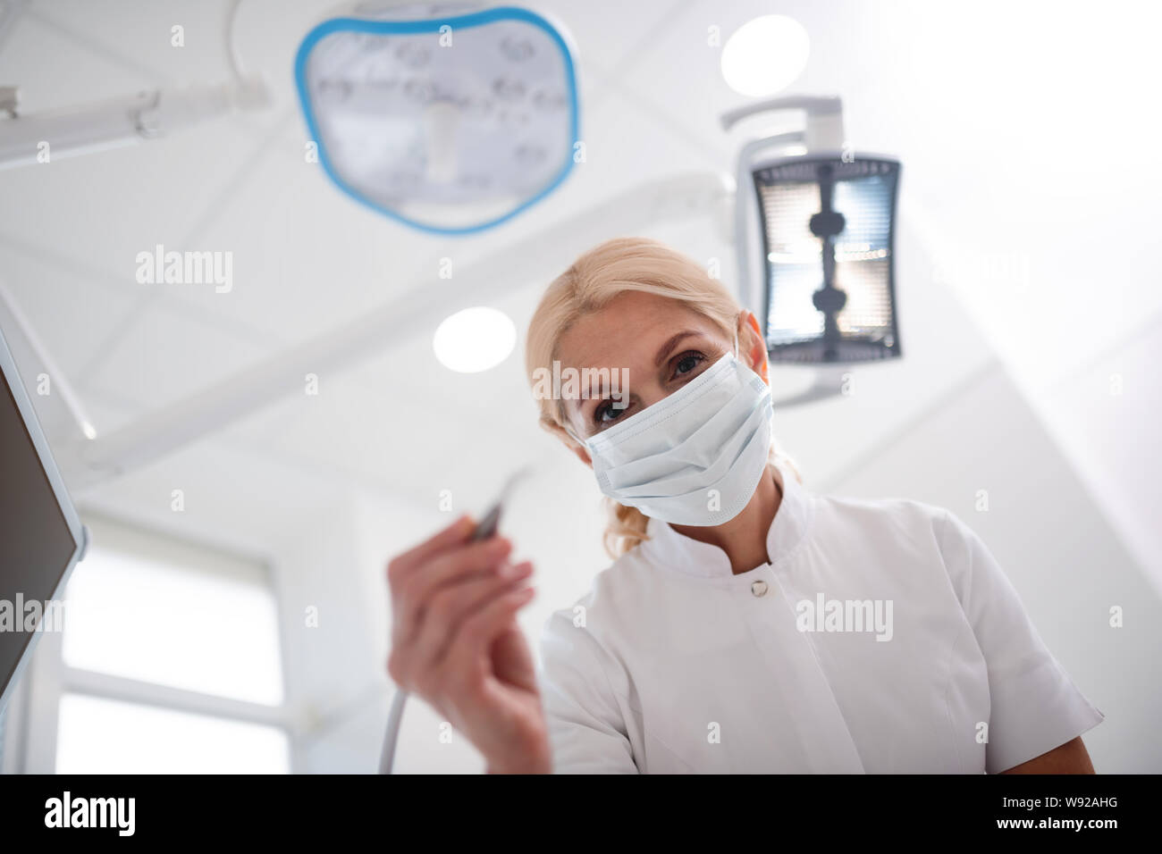 Dentist bending over patient hi-res stock photography and images - Alamy
