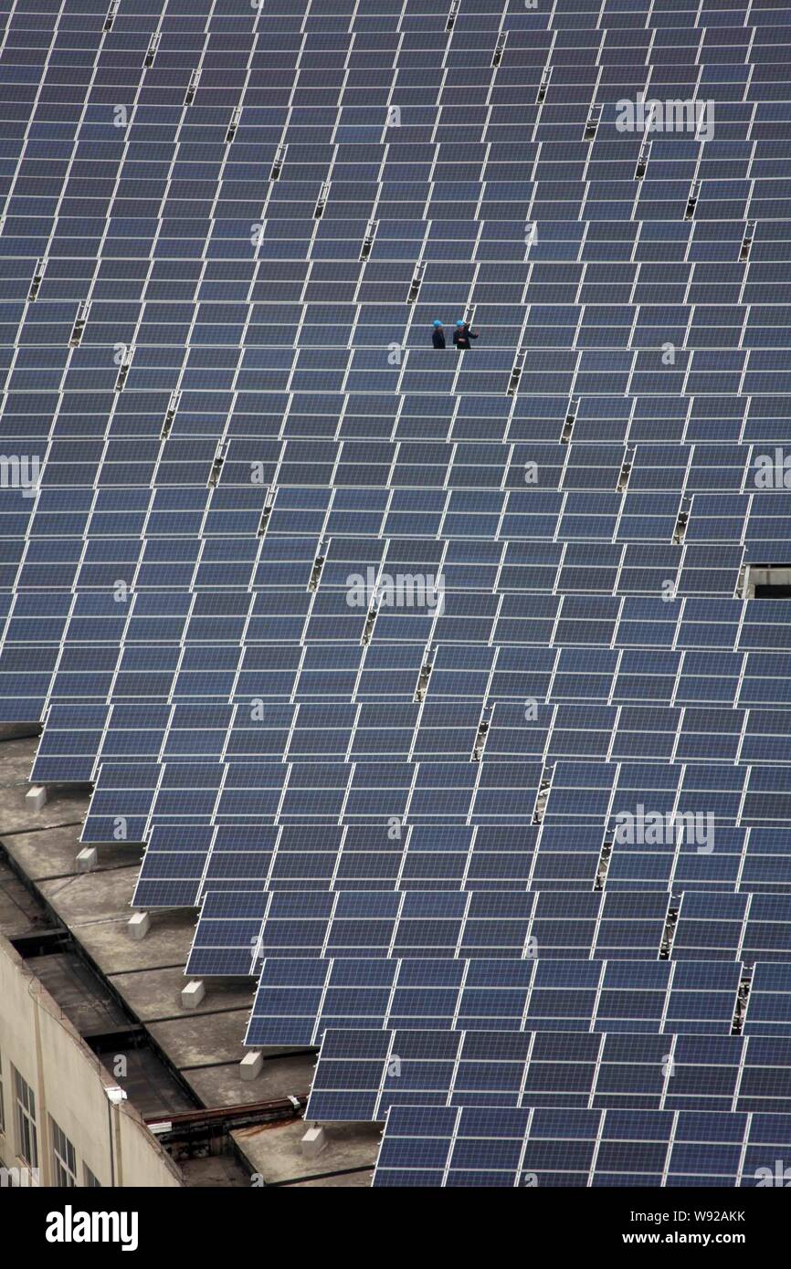 --FILE--Chinese electricians check arrays of solar panels at a rooftop ...