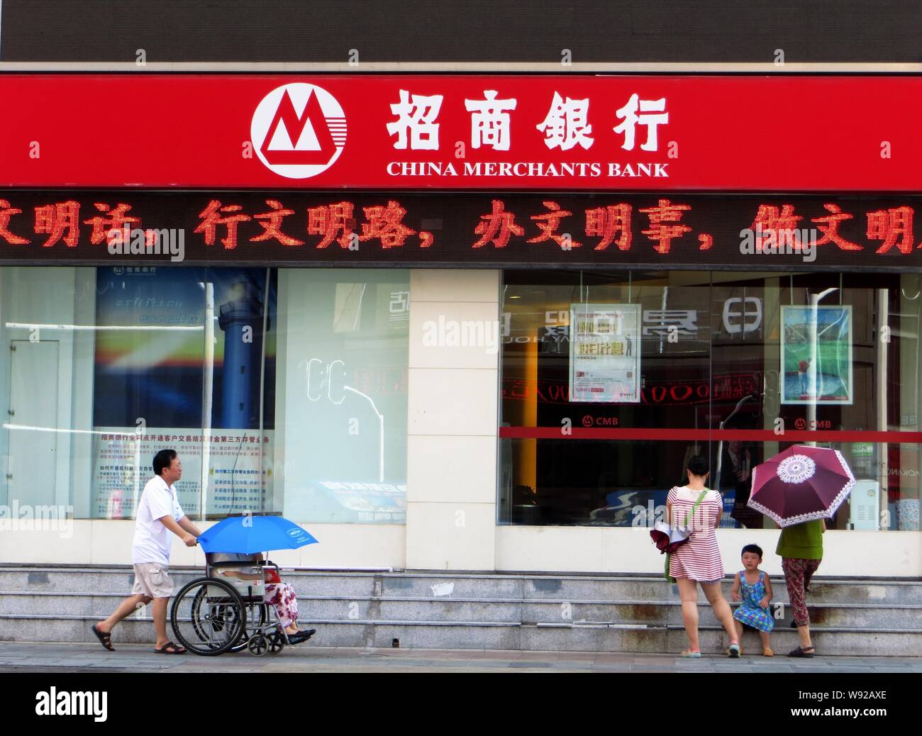 --FILE--Pedestrians stand in front of a branch of China Merchants Bank ...