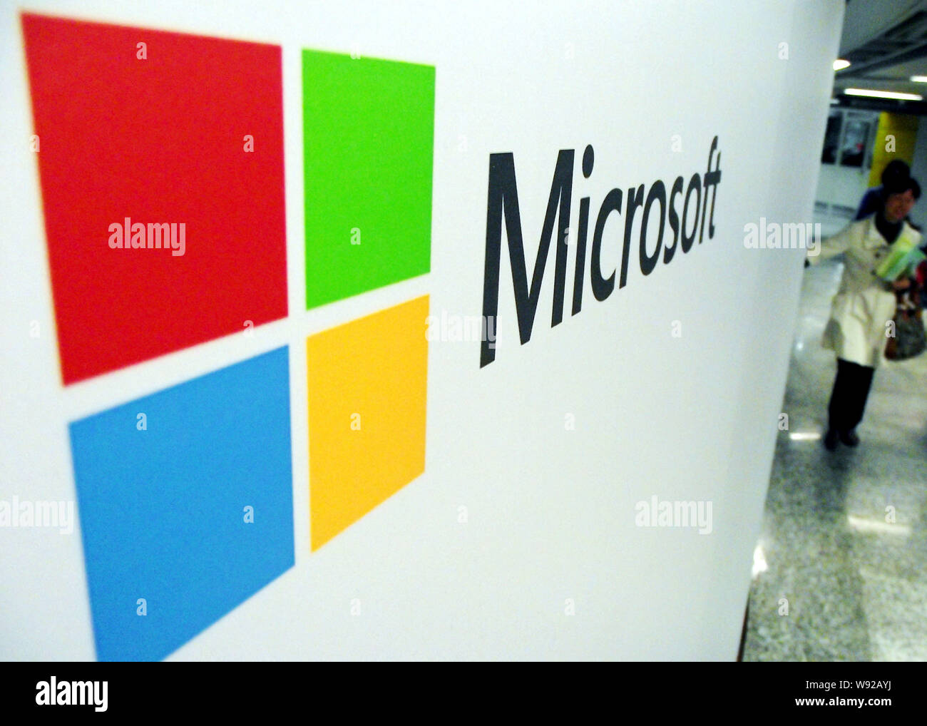 --FILE--A passenger walks past a logo of Microsoft at a metro station ...
