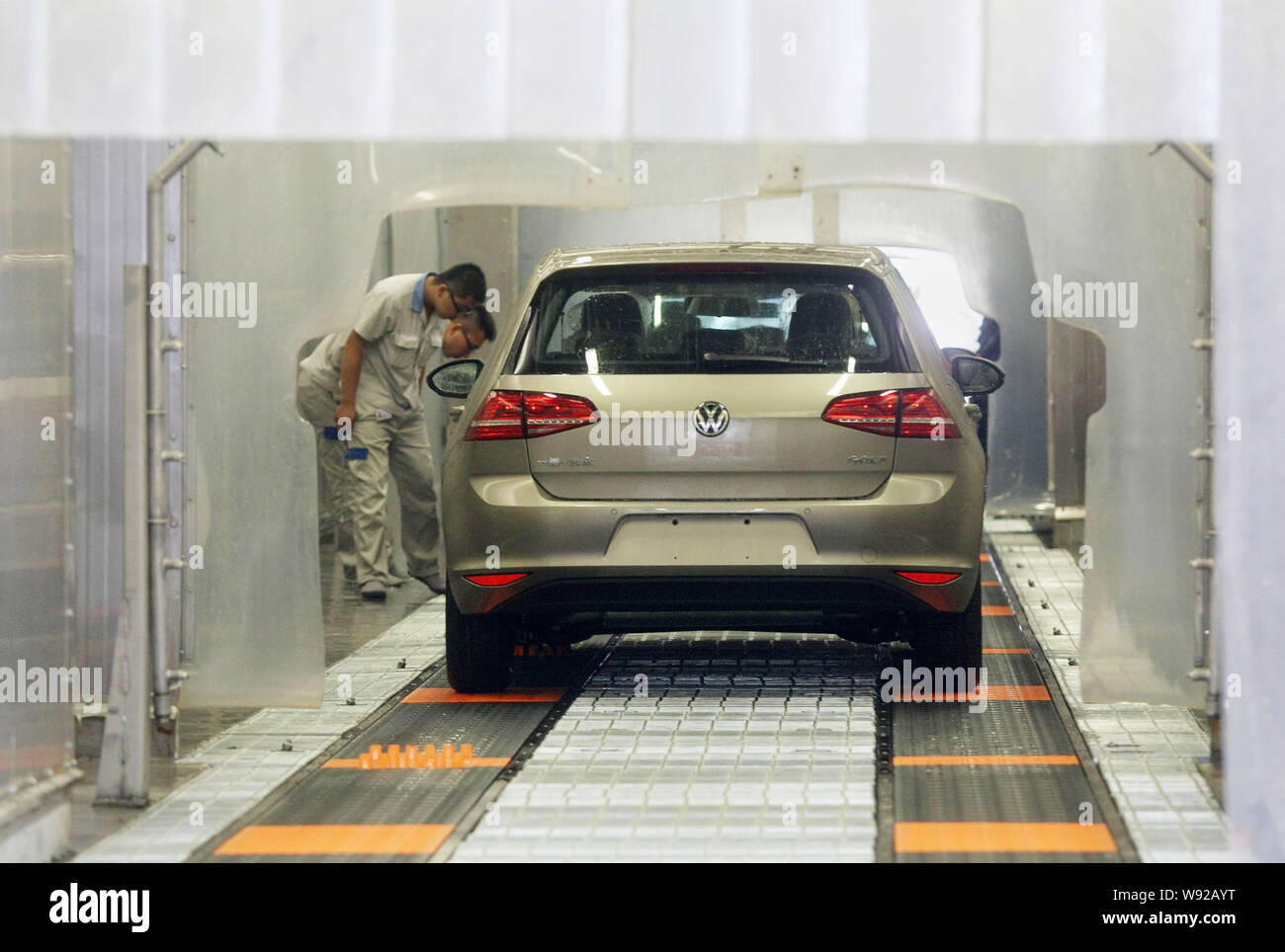 Chinese workers assemble a car on an assembly line at the new plant of ...