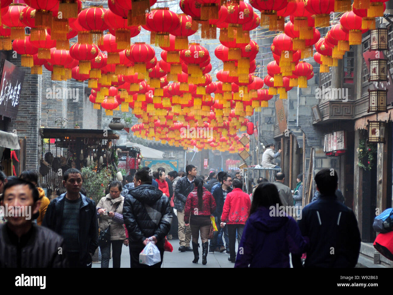 Tourists walk under red lanterns lined up along Jinli Ancient Street to ...