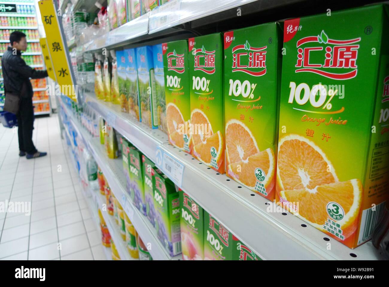 --FILE--A Chinese customer selects cartons of Huiyuan juice in a ...