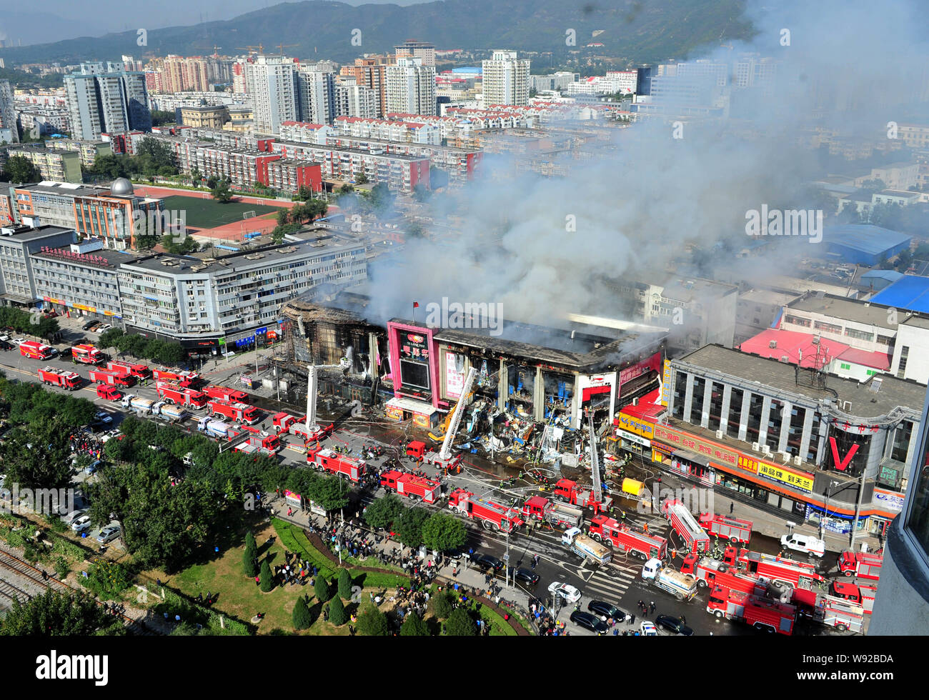Chinese firefighters hose water to extinguish the fire in the Xilongduo ...