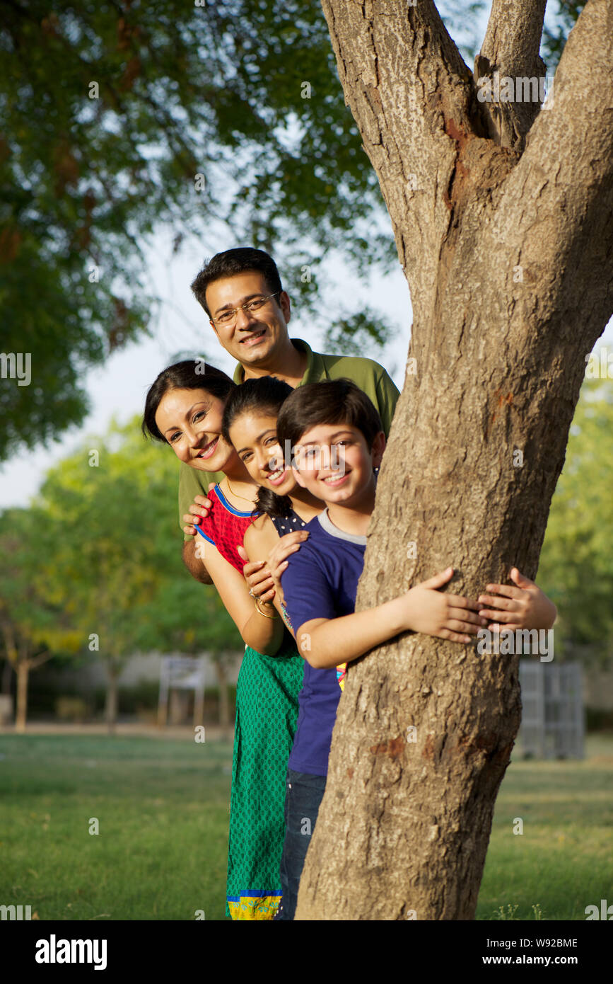 Man peeking from behind tree hi-res stock photography and images - Alamy