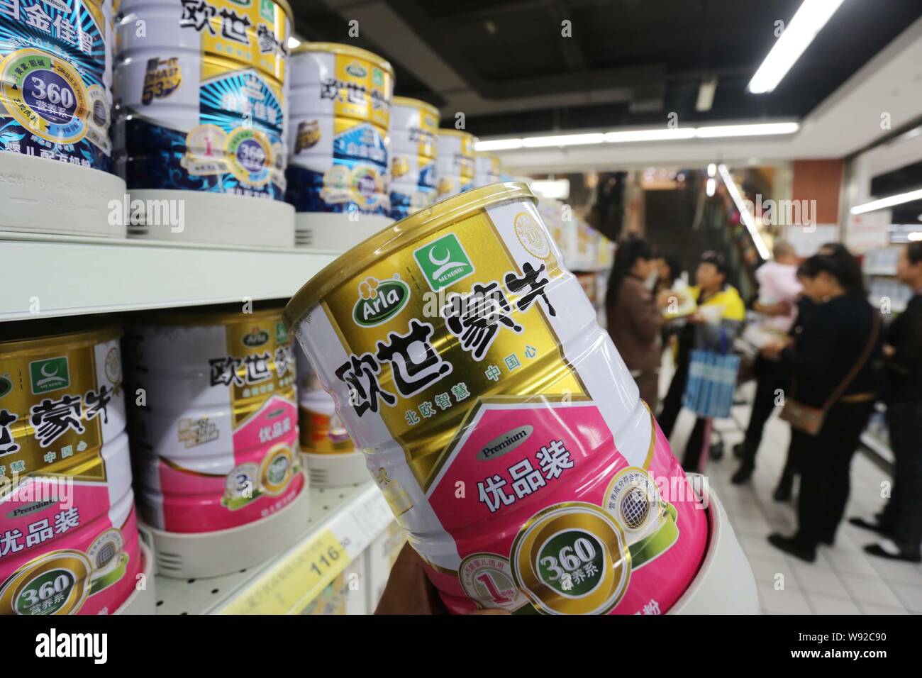 --FILE--A customer buys a tin of Mengniu Arla milk powder at a ...