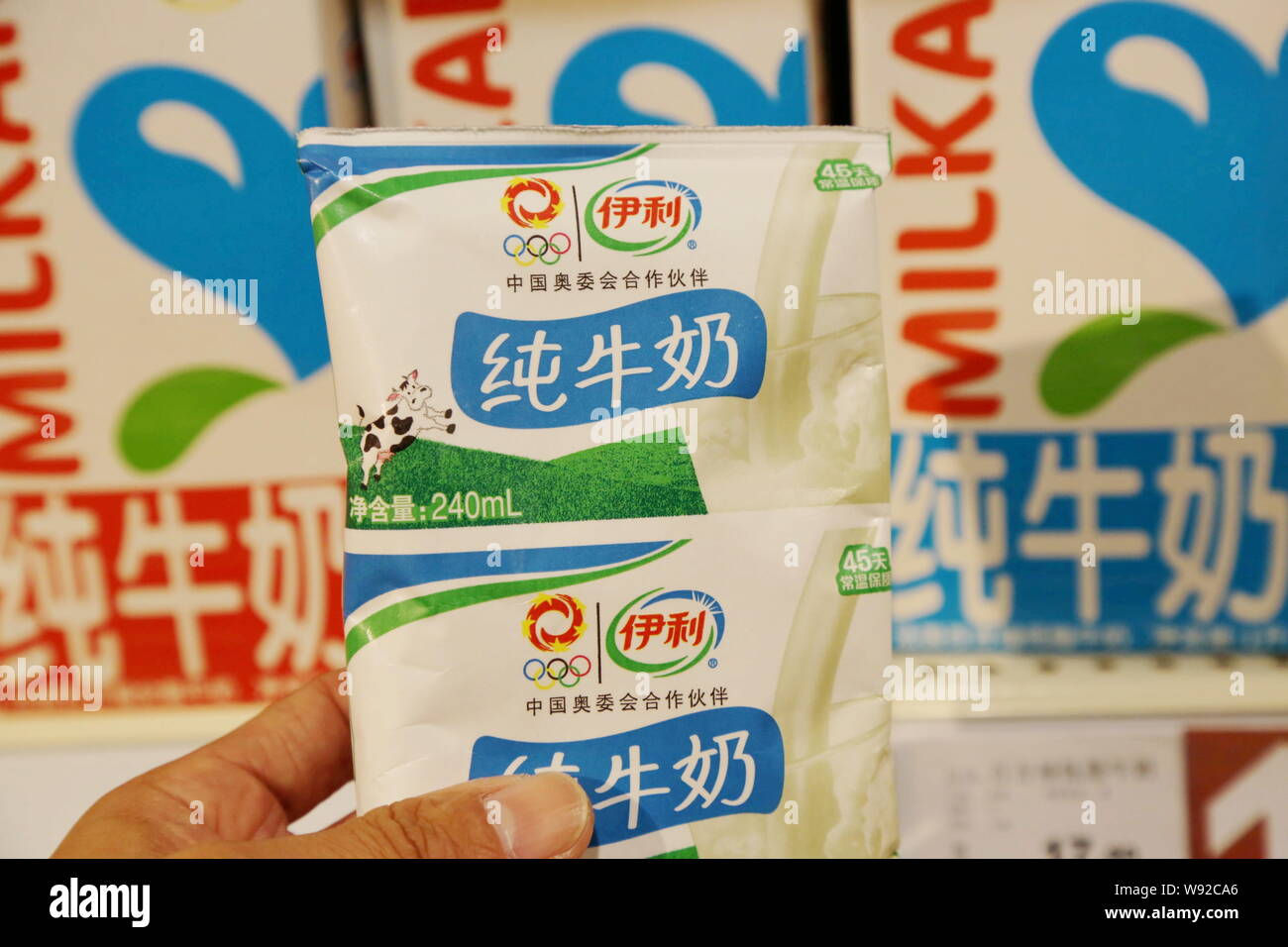 A Chinese customer buys Yili pure milk at a supermarket in Xuchang ...