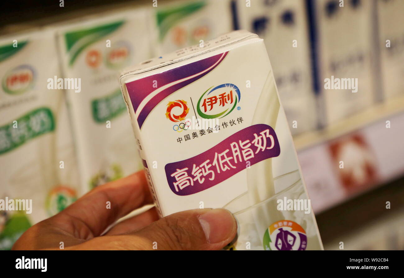A Chinese customer buys Yili milk at a supermarket in Xuchang, central ...
