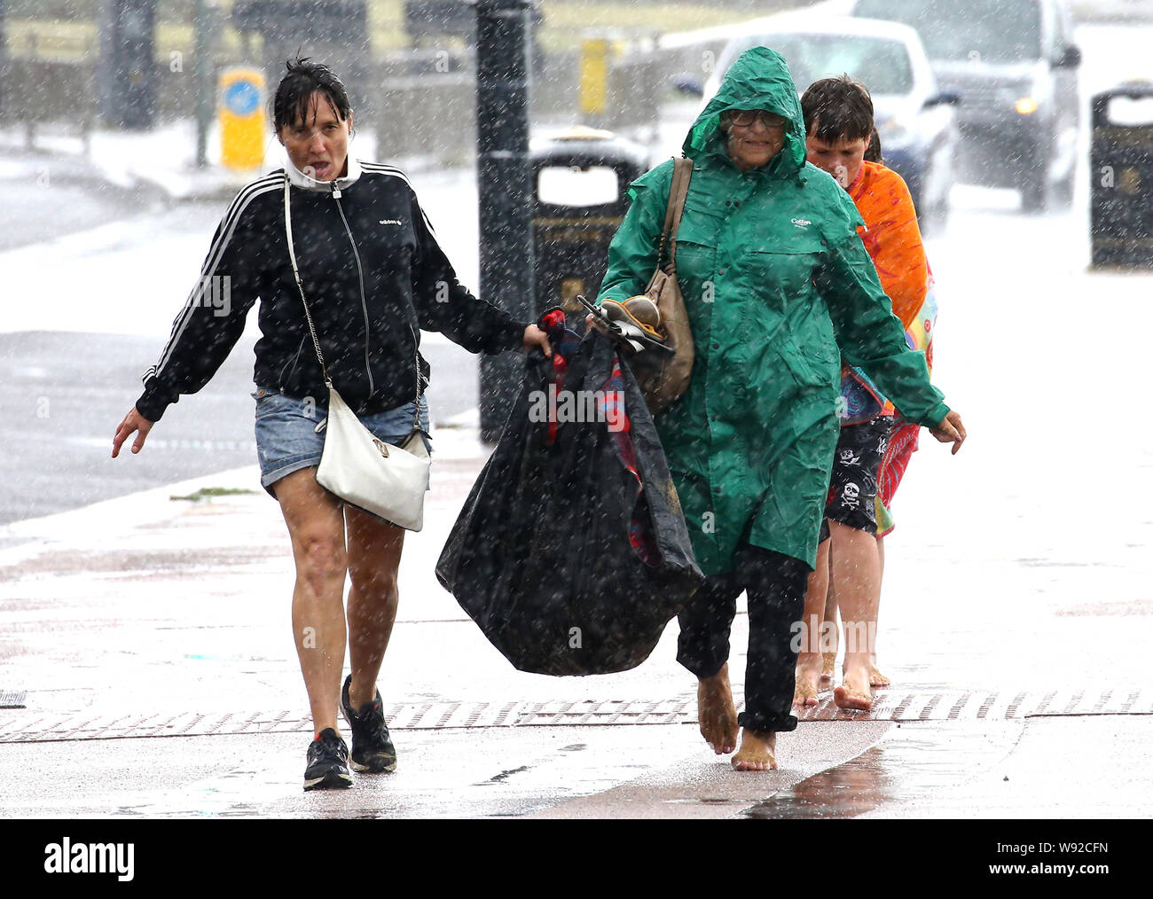 People near the beach in Margate, Kent, during heavy rain as ...
