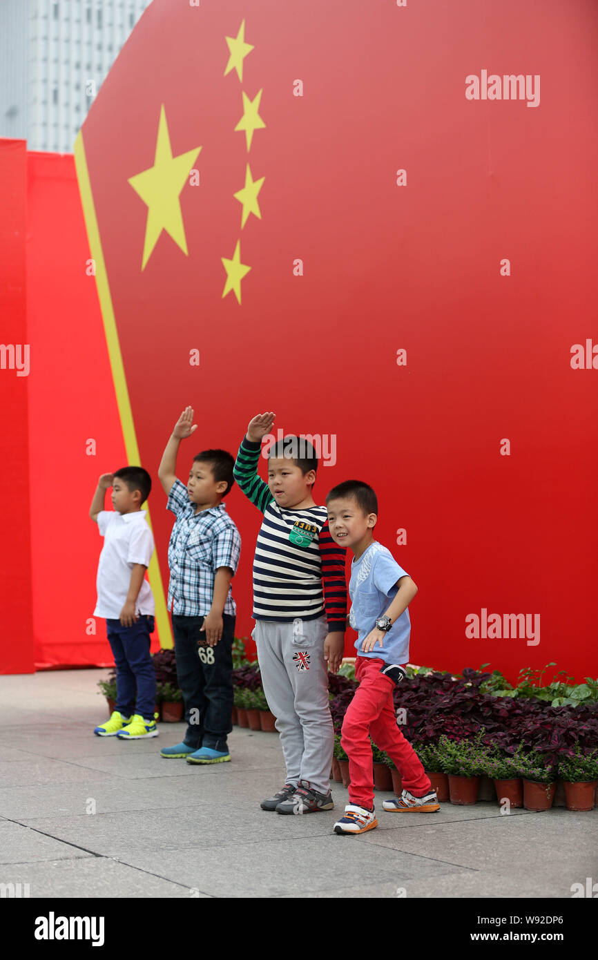 Chinese children salute during a flag-raising ceremony on the National ...