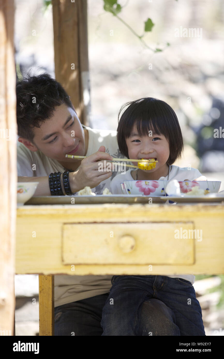 --FILE--Taiwanese singer and actor Jimmy Lin, left, feeds his son Kimi ...
