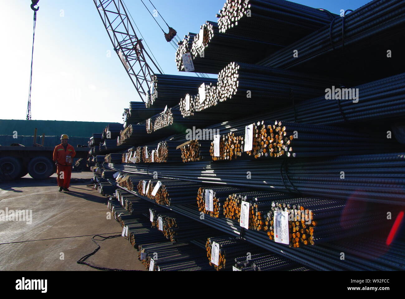 --FILE--A Chinese worker examines a stack of reinforcing steel rods to ...