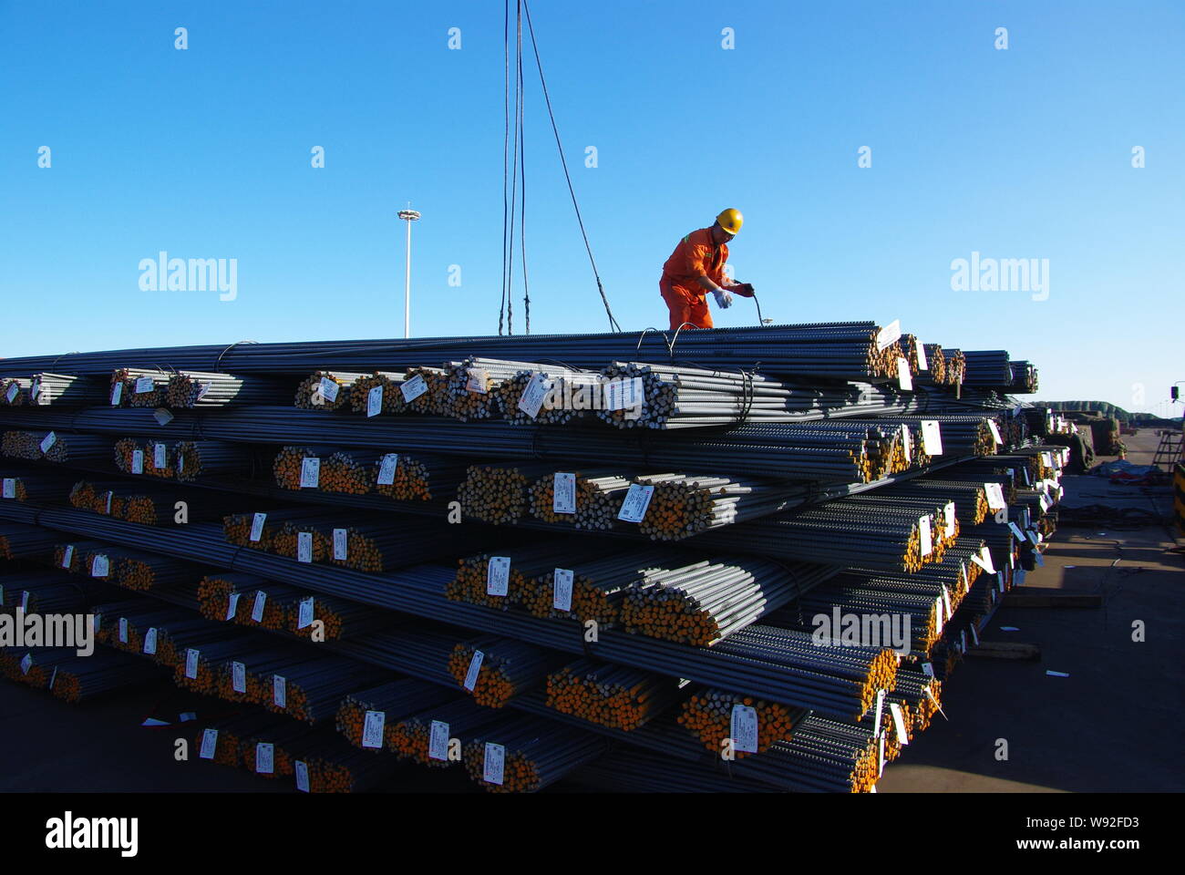 --FILE--A Chinese worker examines a stack of reinforcing steel rods to ...