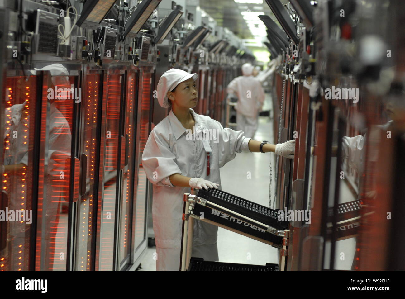 --FILE--A female young Chinese worker checks hard disk drives (HDD) at ...