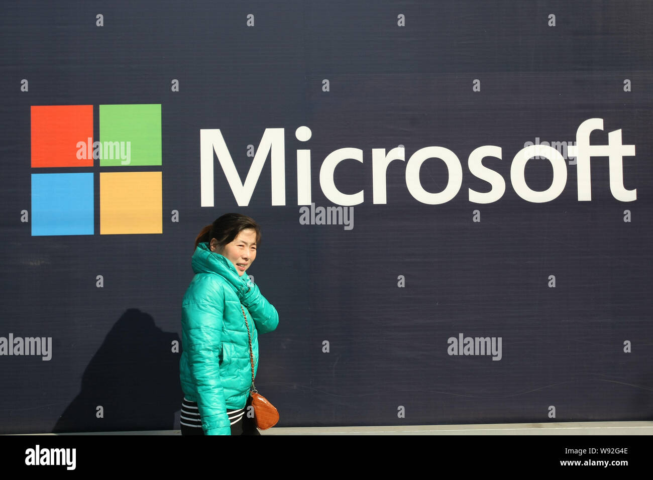 --FILE--A pedestrian walks past a logo of Microsoft in Shanghai, China ...