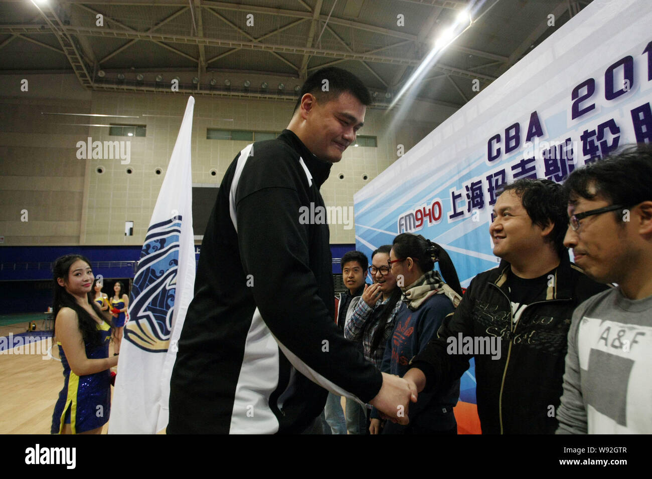 Former NBA basketball player Yao Ming, center, shakes hands with ...