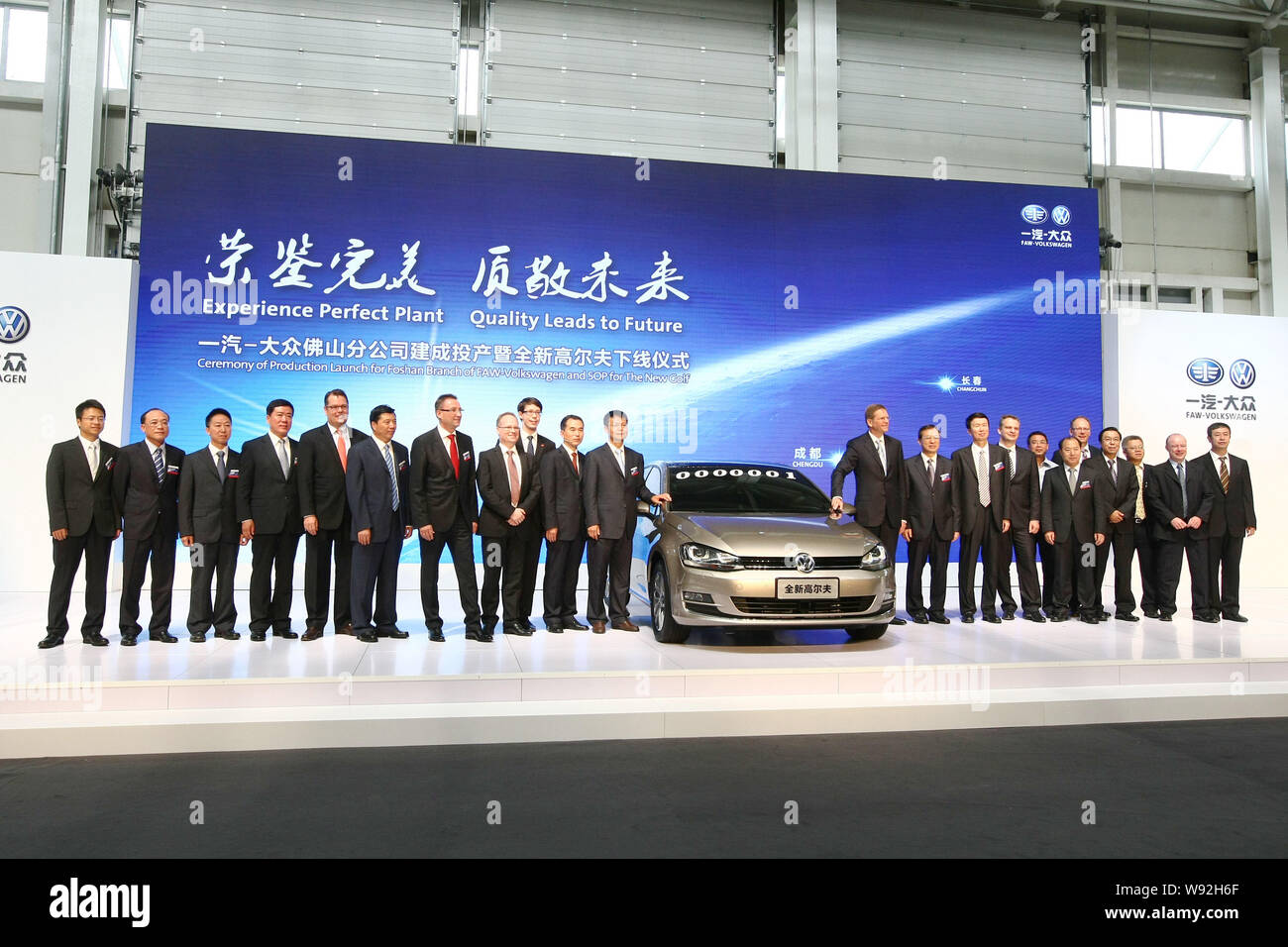 Chinese and foreign employees pose with a Volkswagen Golf 7 of FAW ...