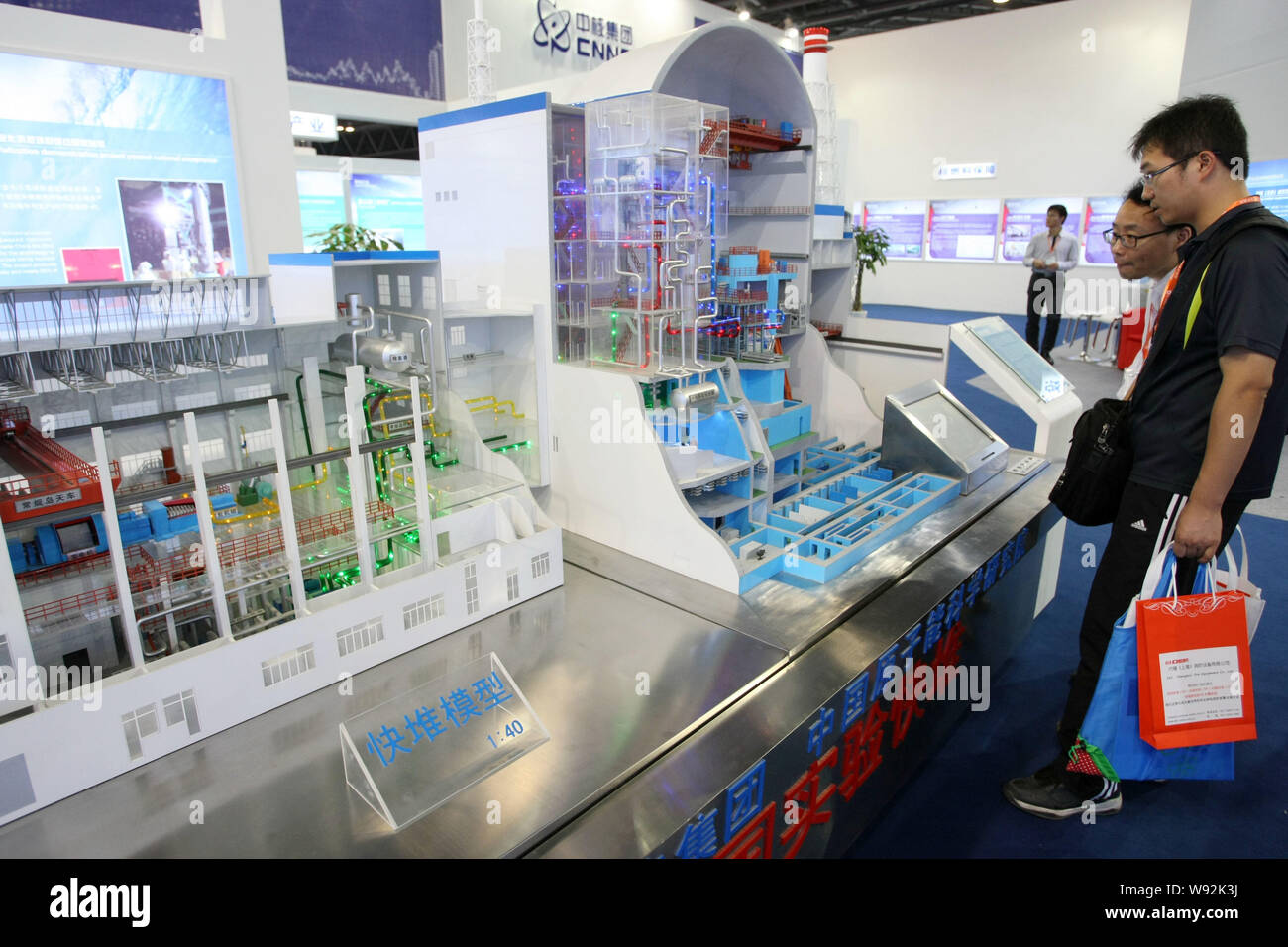 Visitors look at a model of a nuclear power plant at the stand of China ...