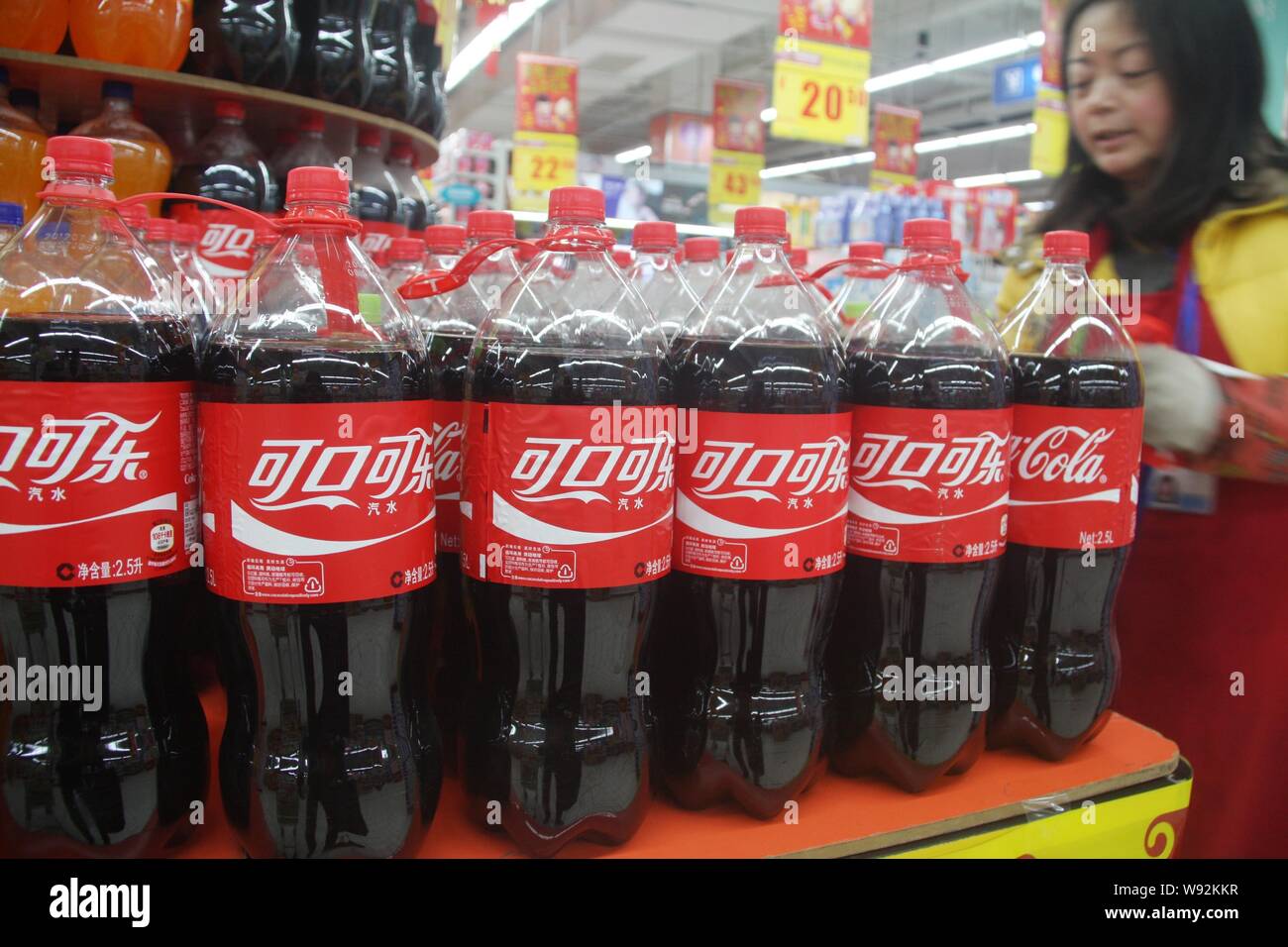 --FILE--A Chinese employee puts bottles of cola drink of Coca-Cola on ...