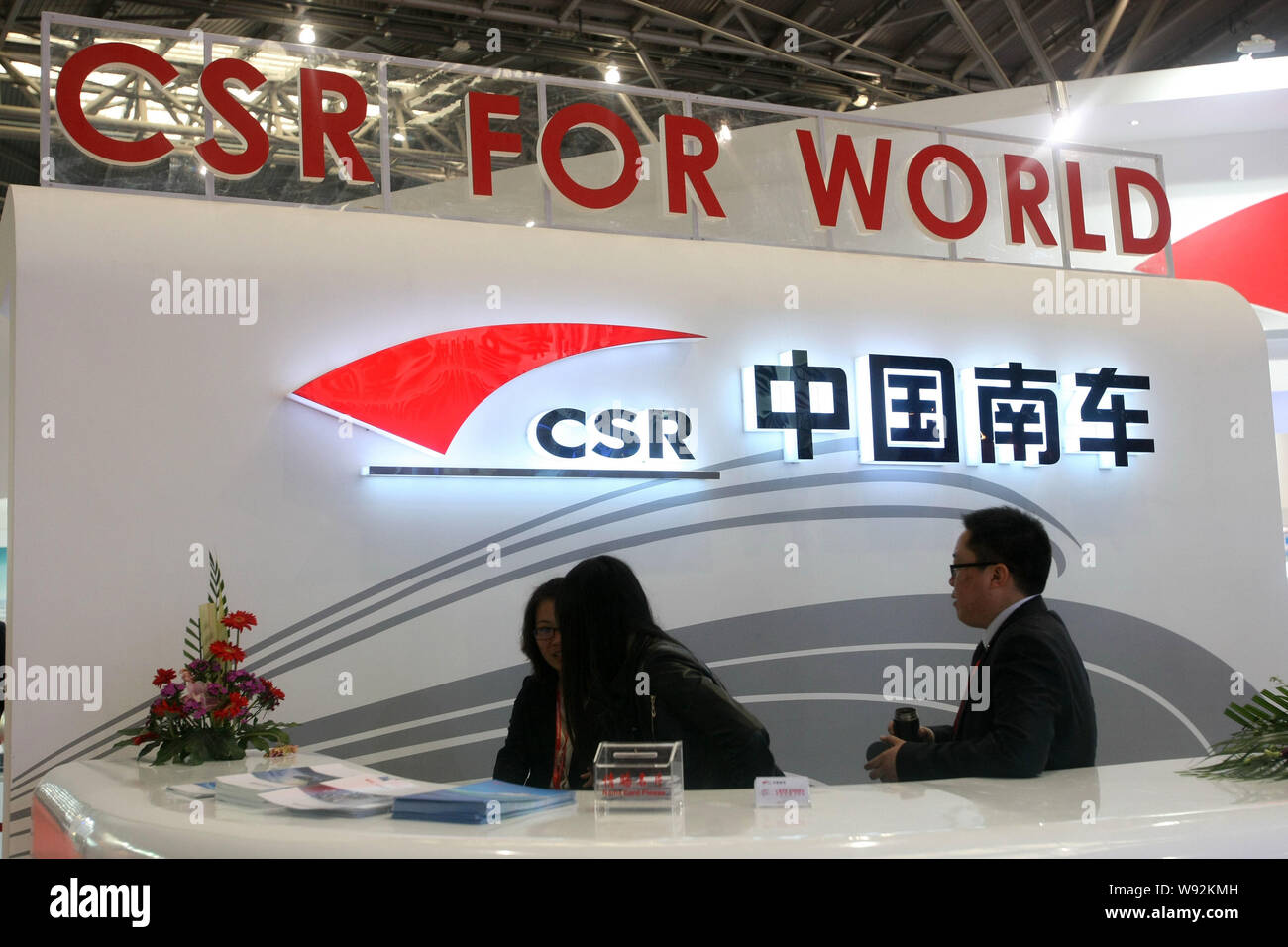 Chinese employees are seen at the stand of CSR (China South Locomotive ...
