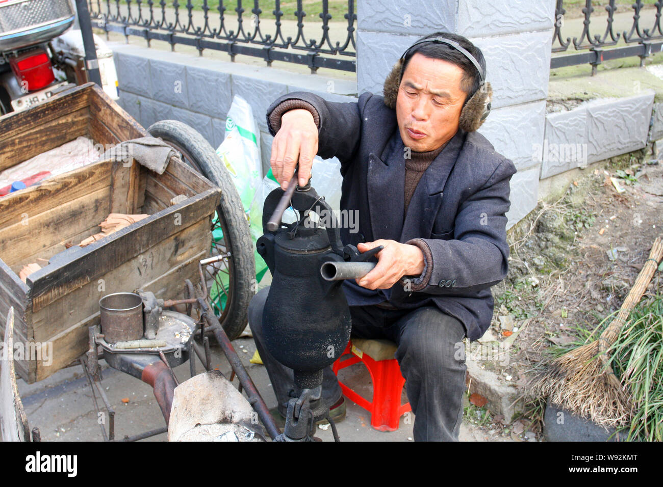 A Chinese vendor closes the cover of an old-fashioned cooker to make ...