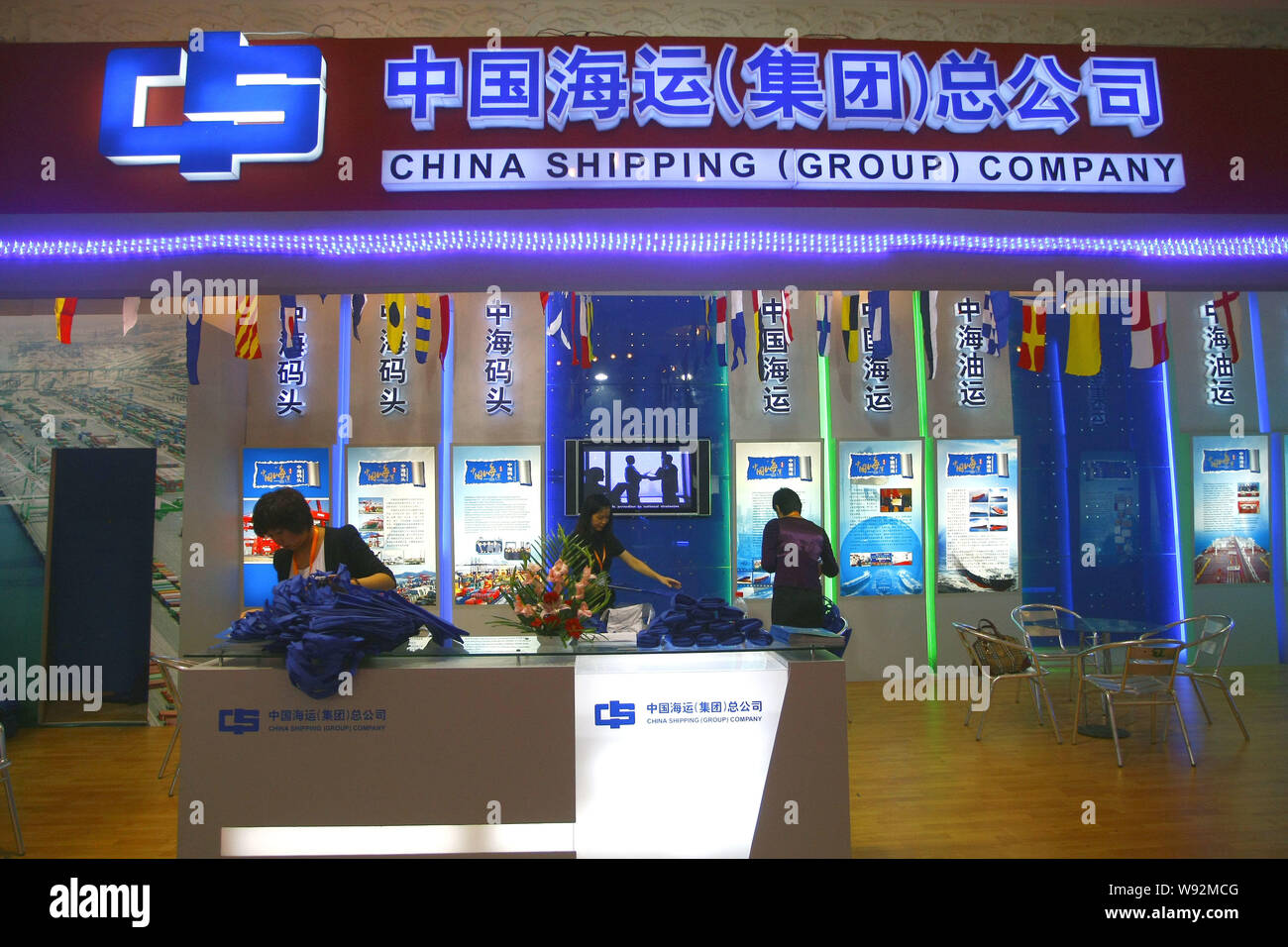 --FILE--Chinese employees work at the stand of China Shipping Group ...