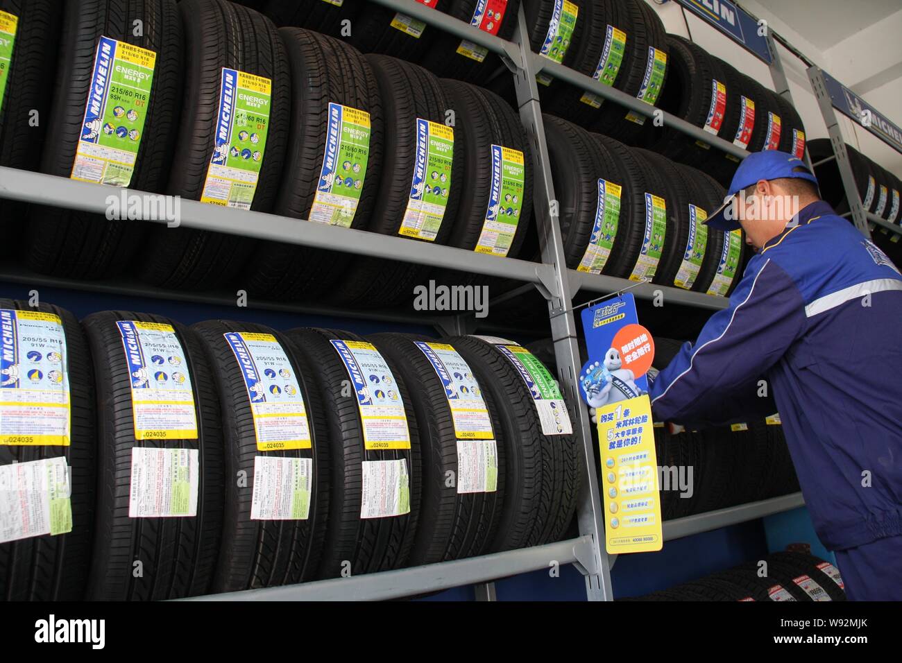 --FILE--A Chinese worker puts Michelin tires on the shelf at a tire ...